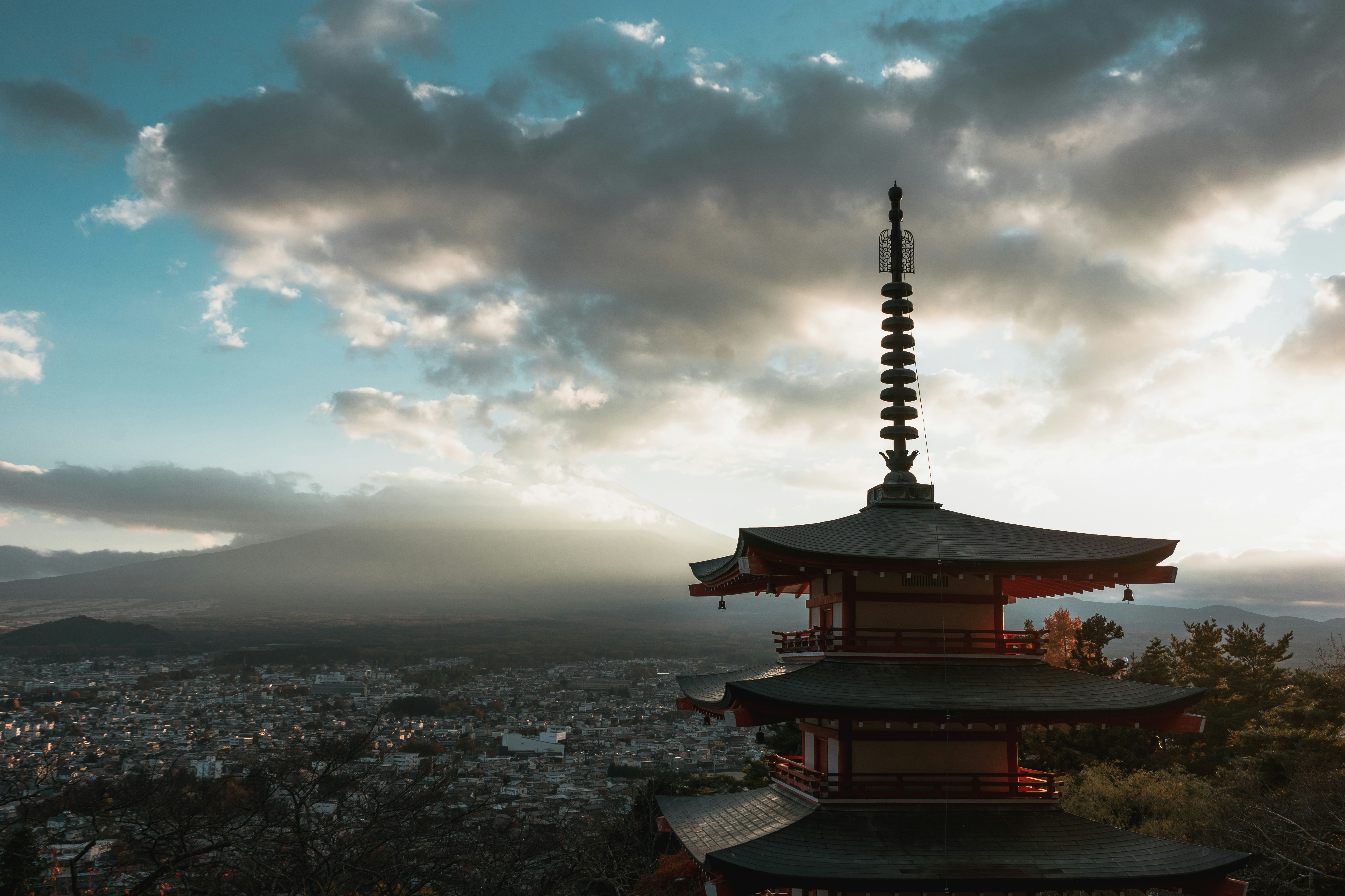 Sunset Over a Japanese Pagoda: A Towering Silhouette Against a Clouded Sky