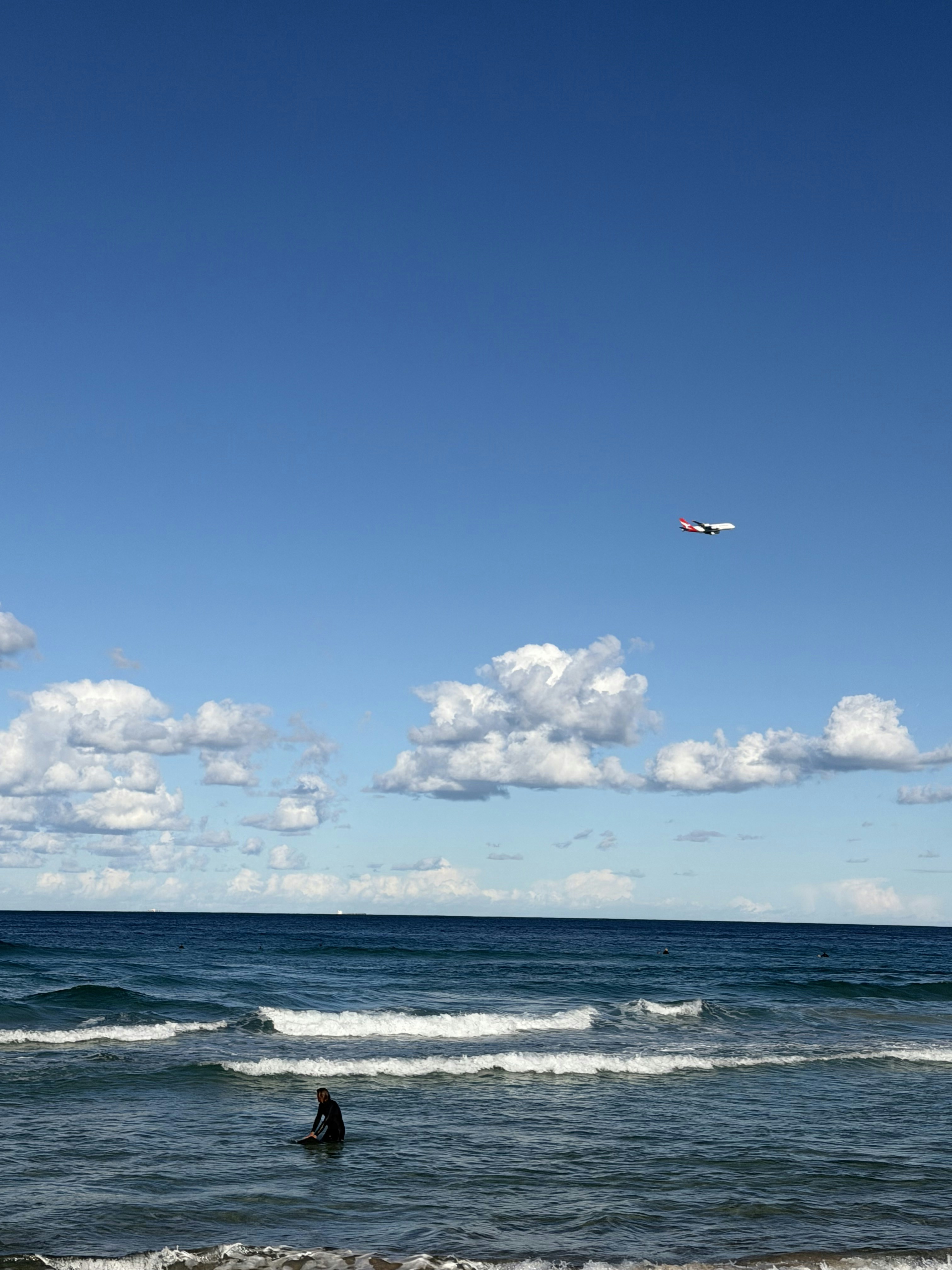 Lie of the Horizon: A Lone Surfer Seems to Glide Under a Wide Sky