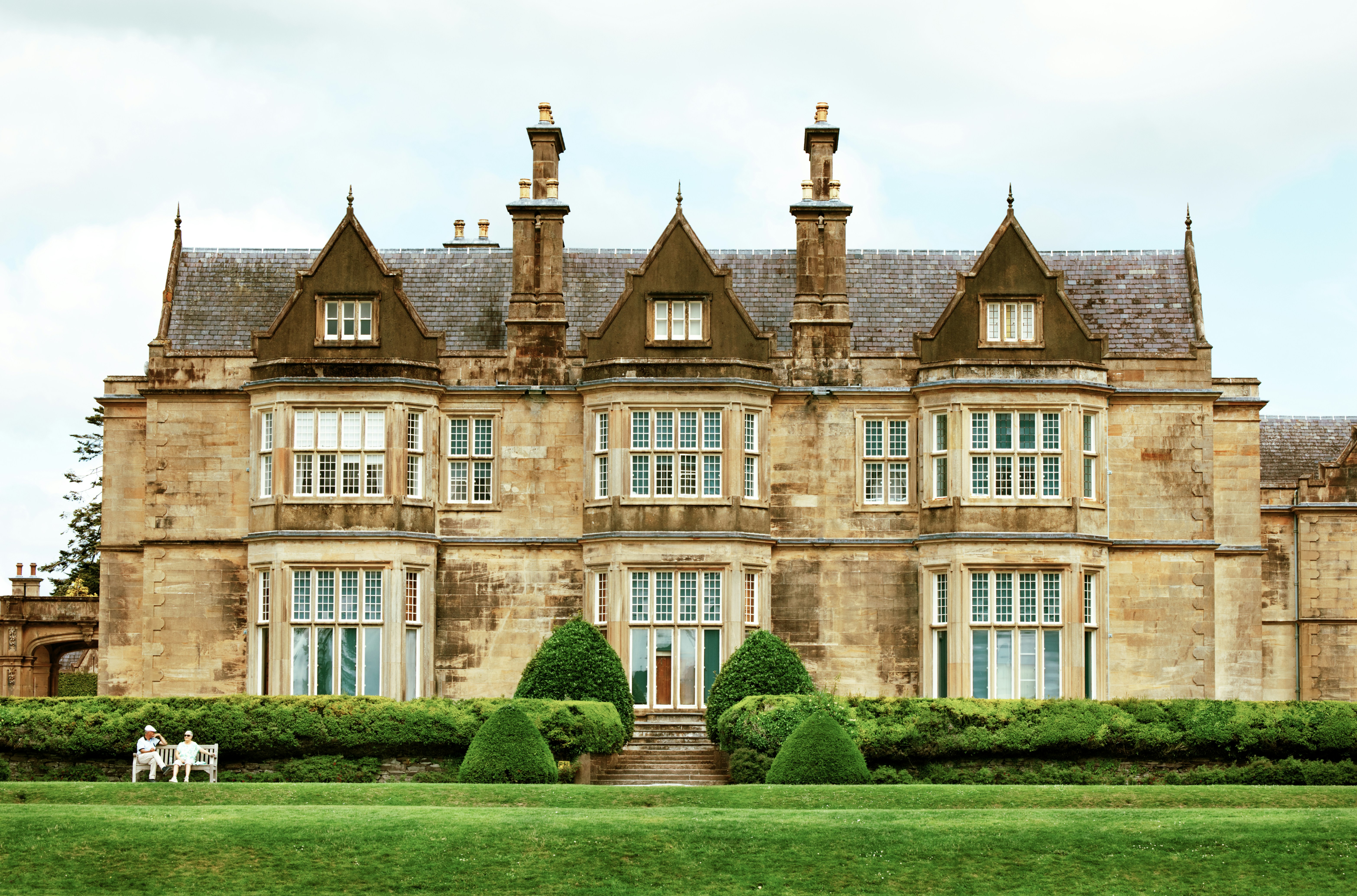  stately manor in symmetrical English estate with sculpted hedges