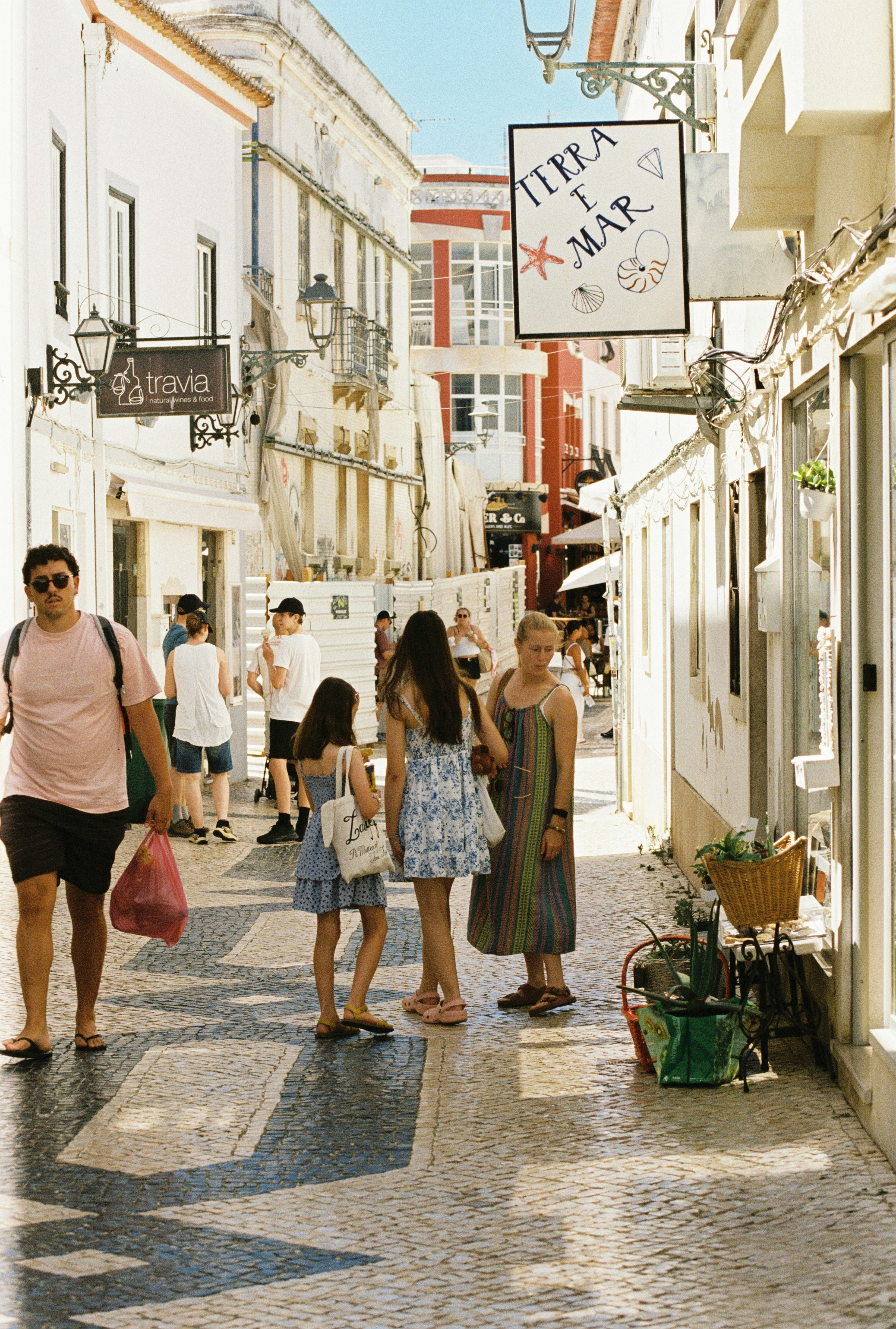 Sunlit Rua de Graça: a Mediterranean street of pedestrians and pastel façades