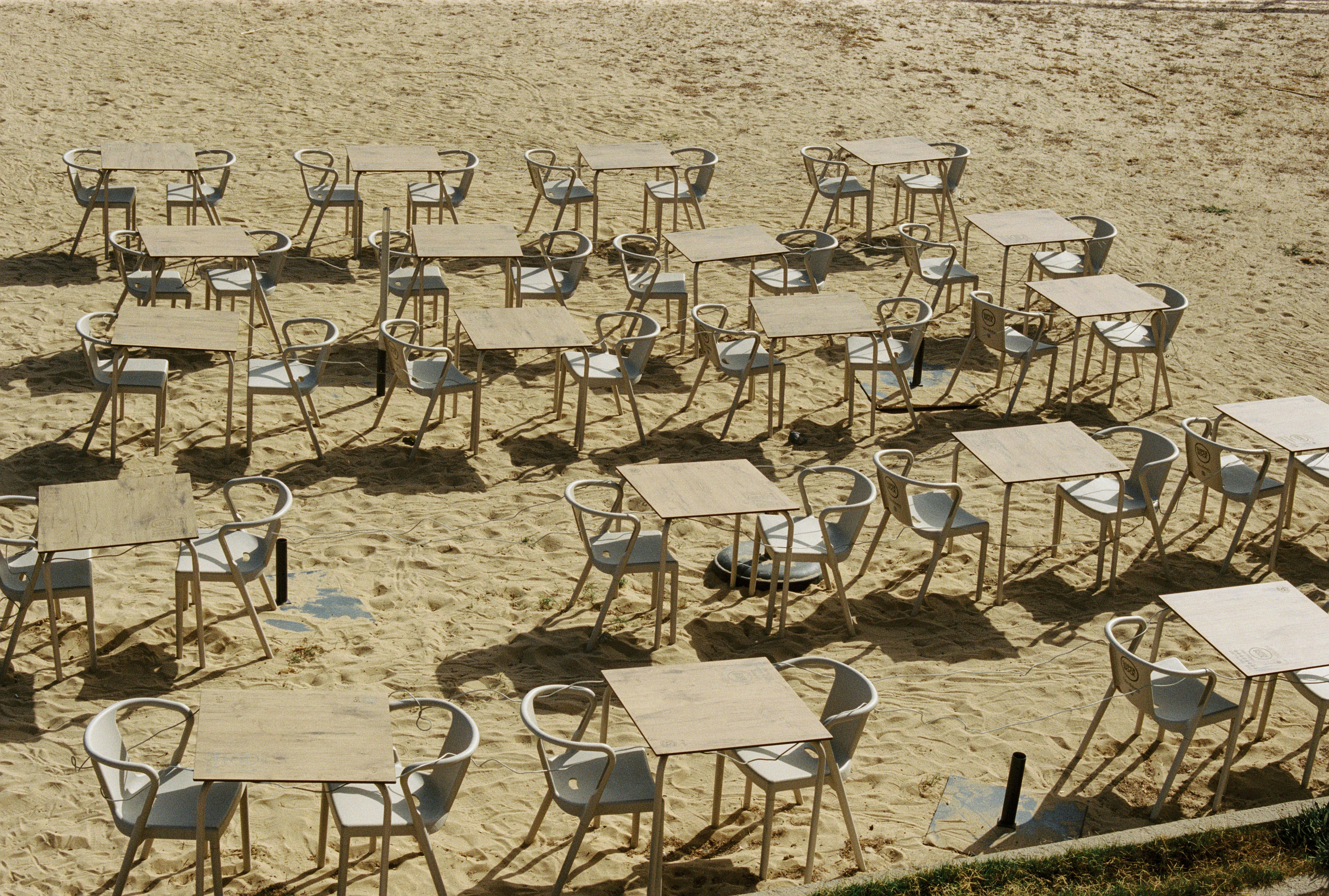 Deserted Beach Classrooms: A Field of Empty Desks on Sand