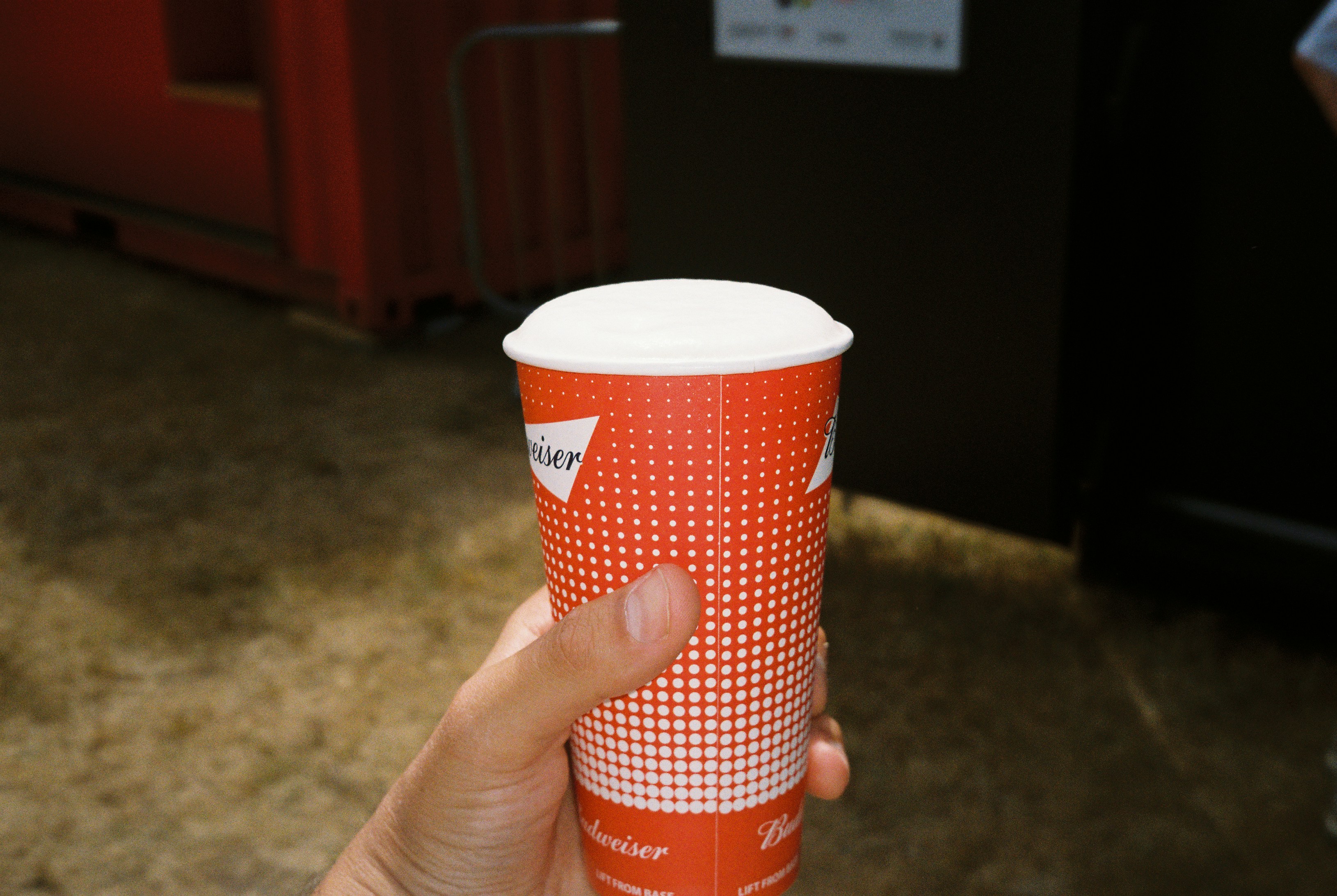 Grip and Foam: A Handful of Coffee in a Bright Orange Cup