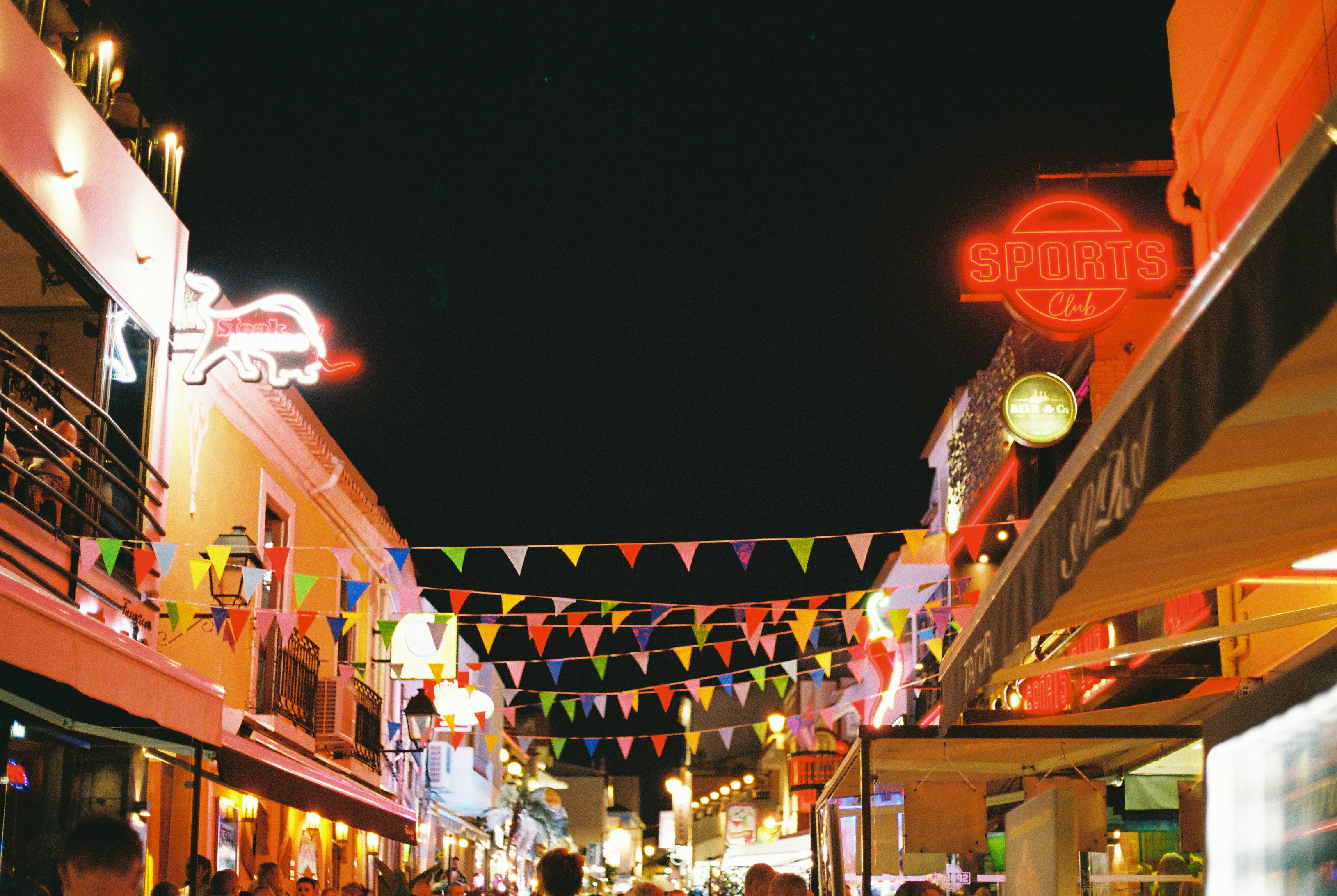 Neon Night Walk Under Colorful Banners