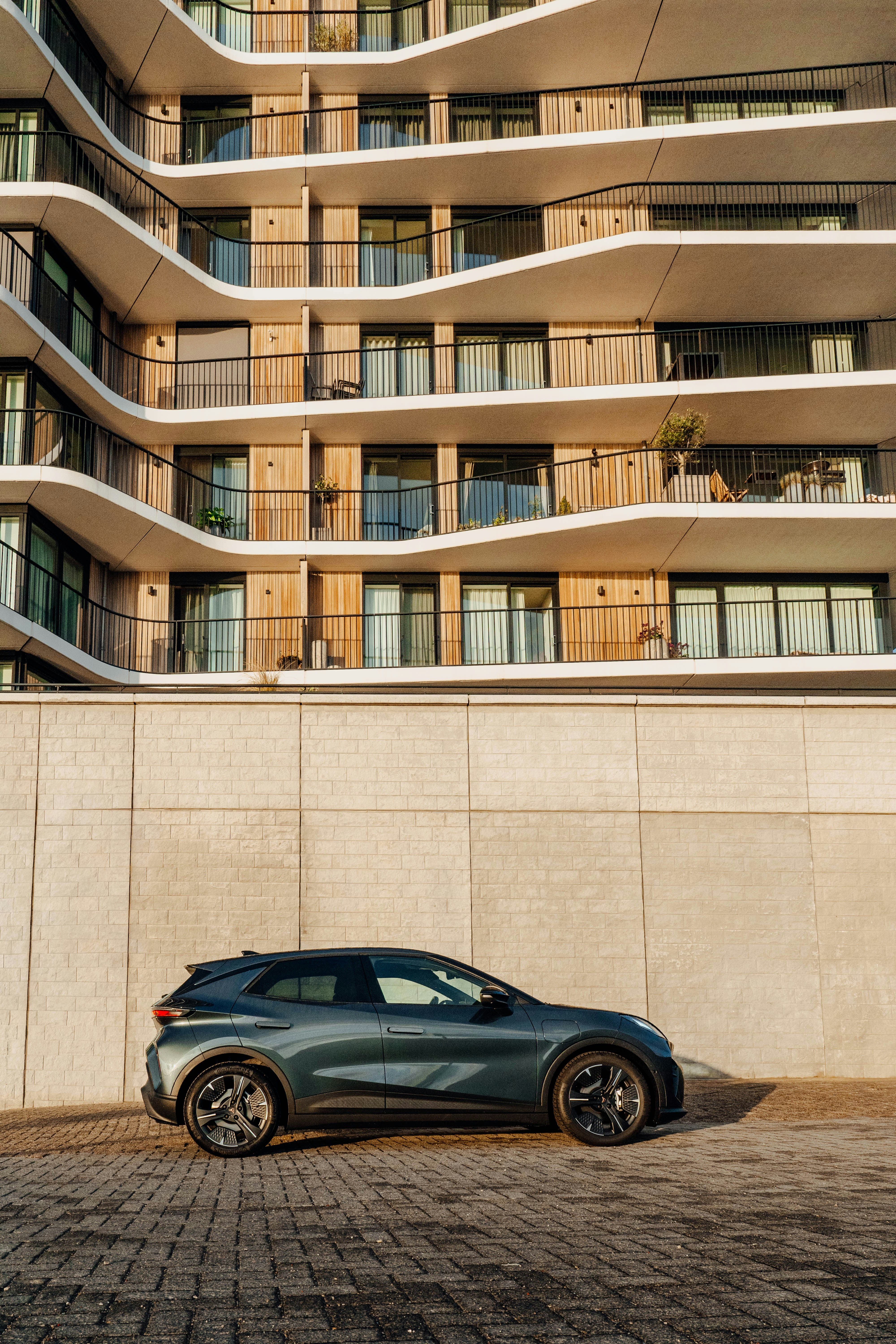 Urban curves and chrome: a sedan under stacked balconies