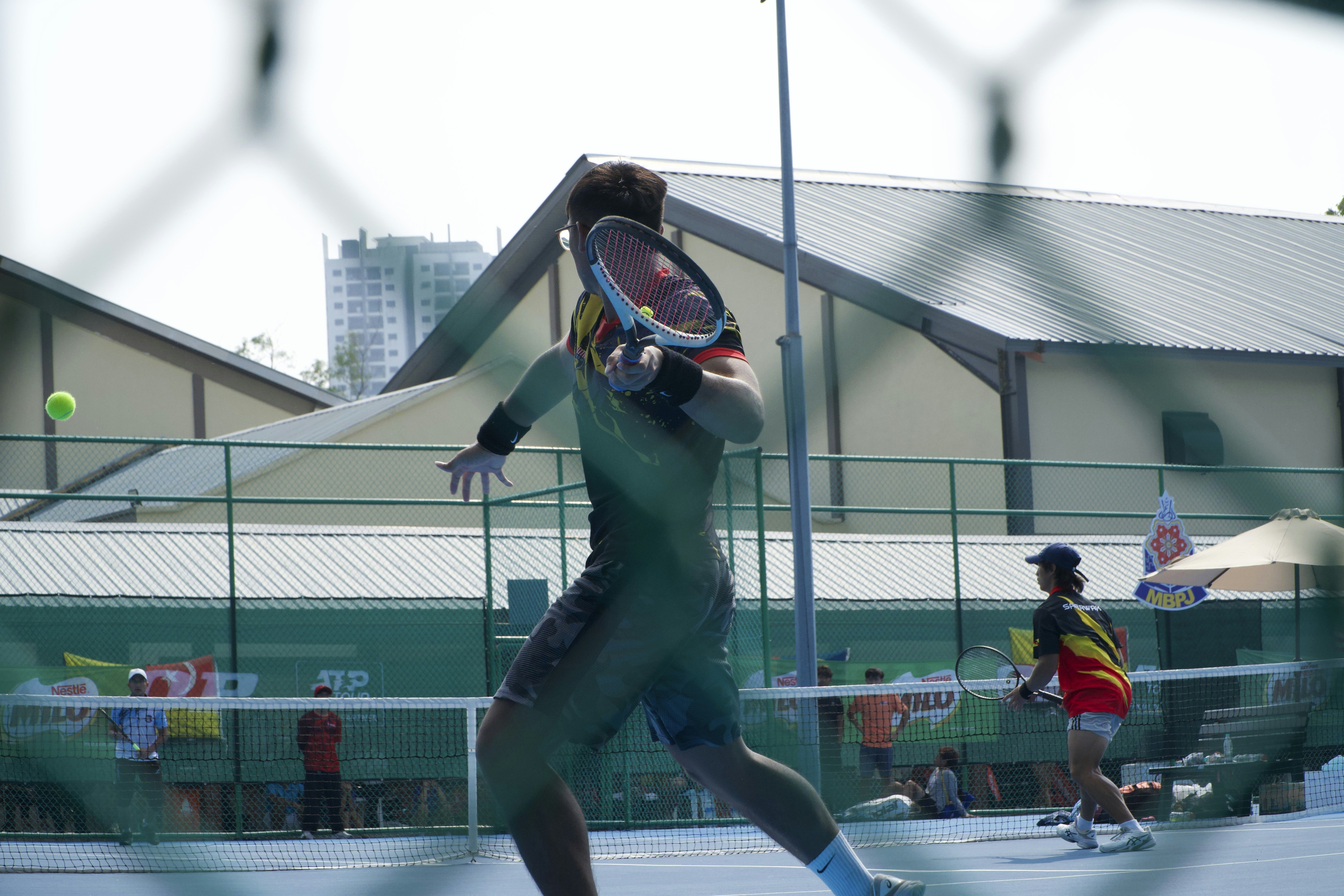 Tennis Rally Through the Mesh of the Court Fence