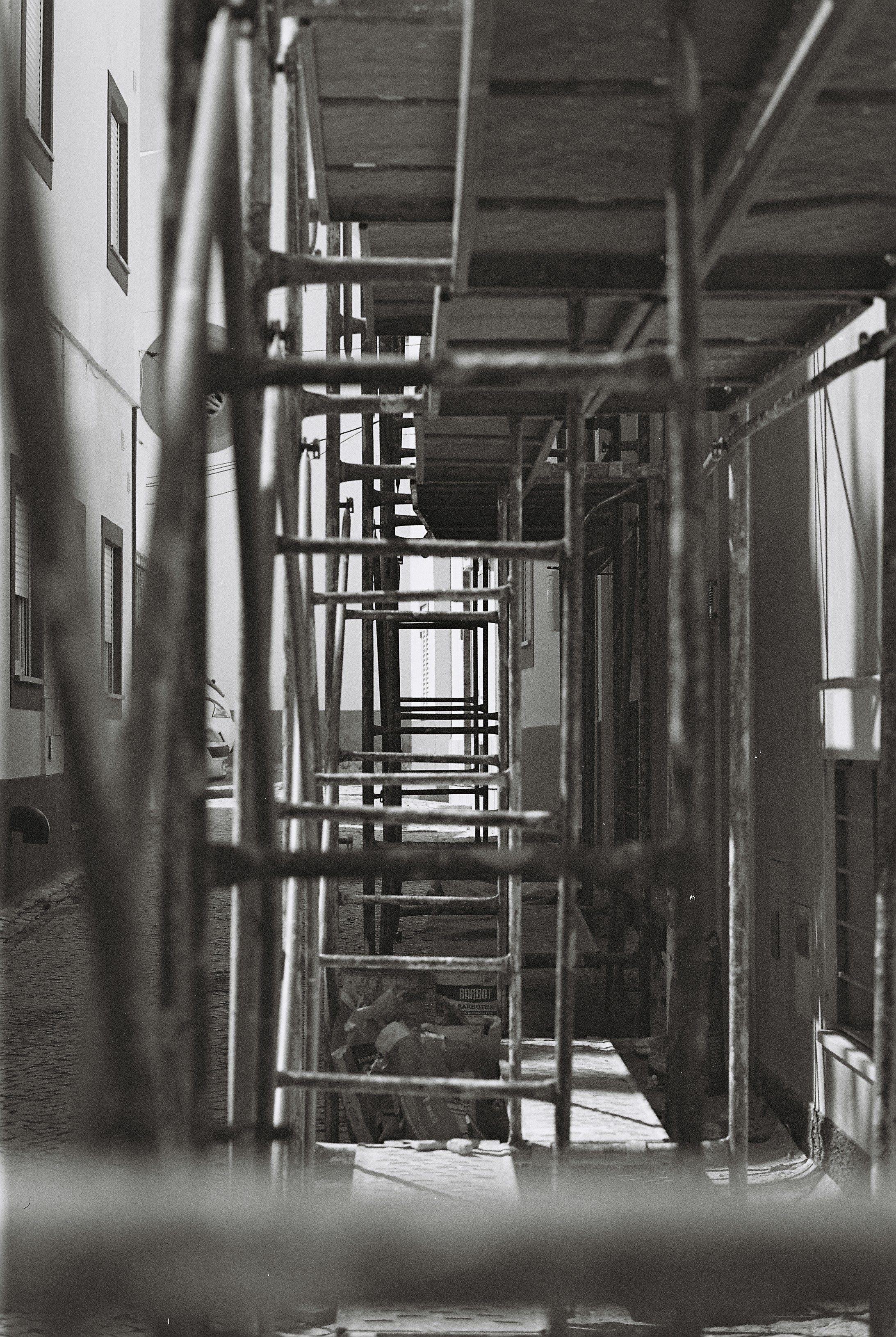 Urban Scaffold Corridor: A Monochrome Odyssey Through Narrow Gaps