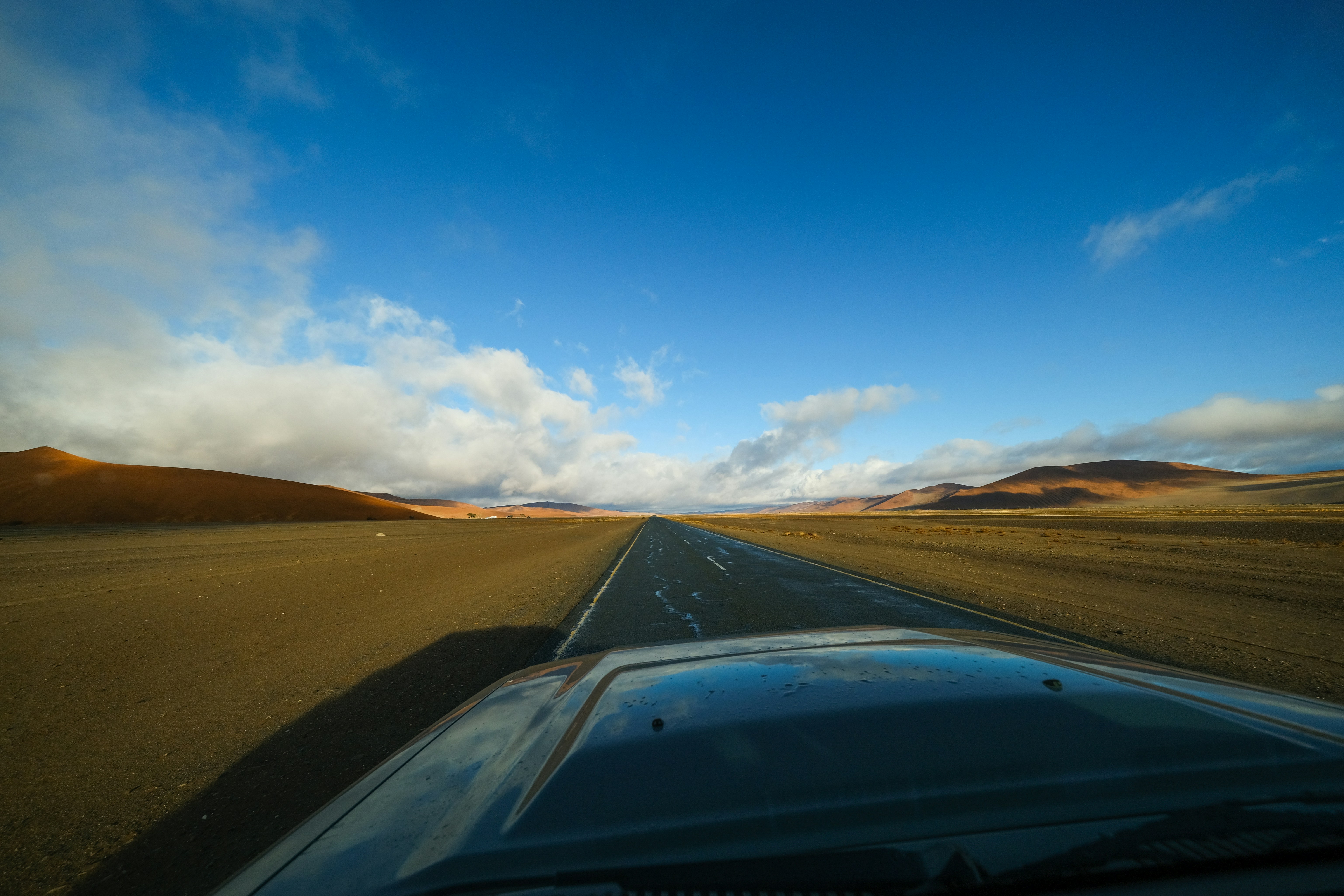 Horizon Highway: A Car’s Narrow Arc into the Desert Dawn