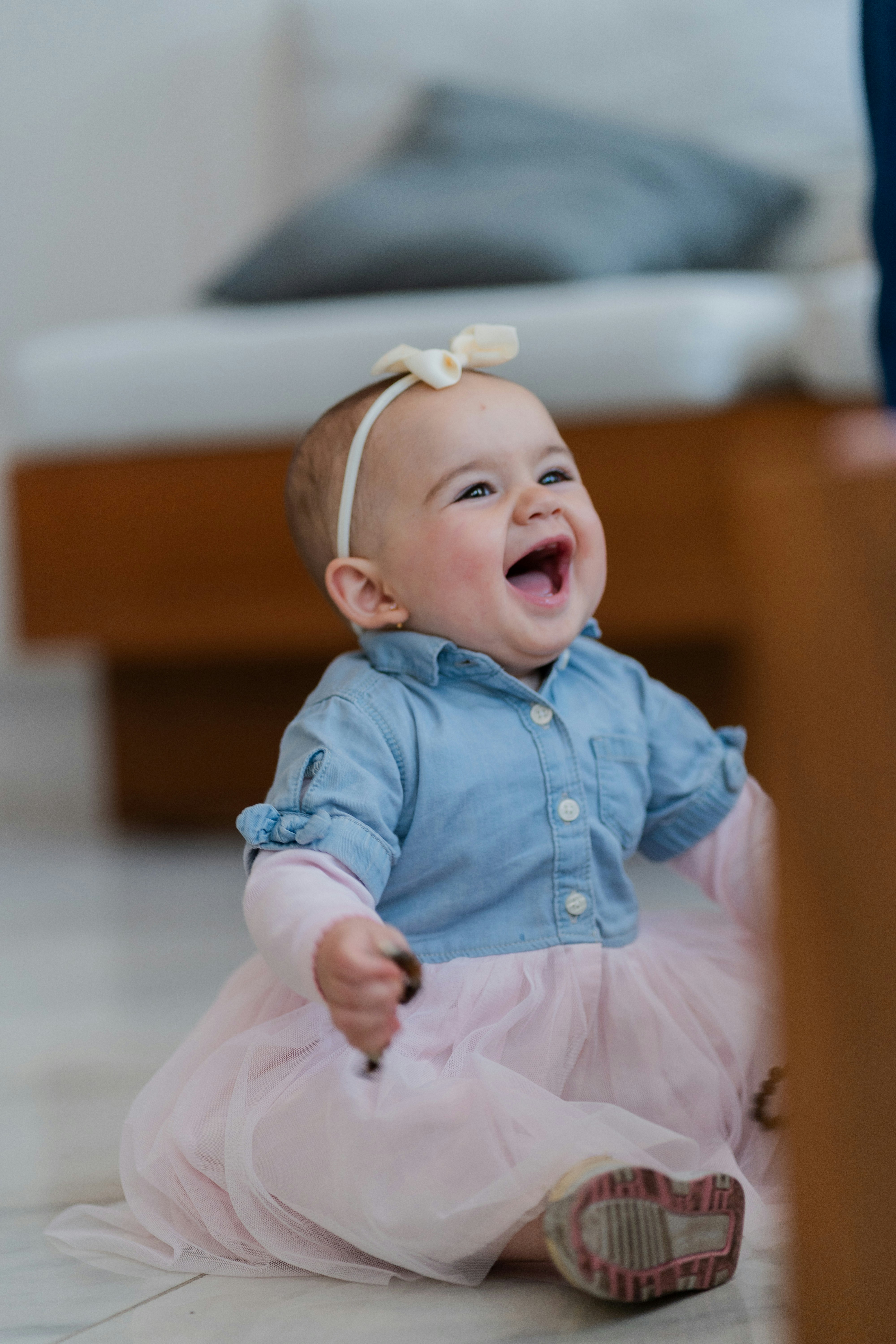 Joyful First Steps: A Baby's Laughter on a Soft Pink Dress