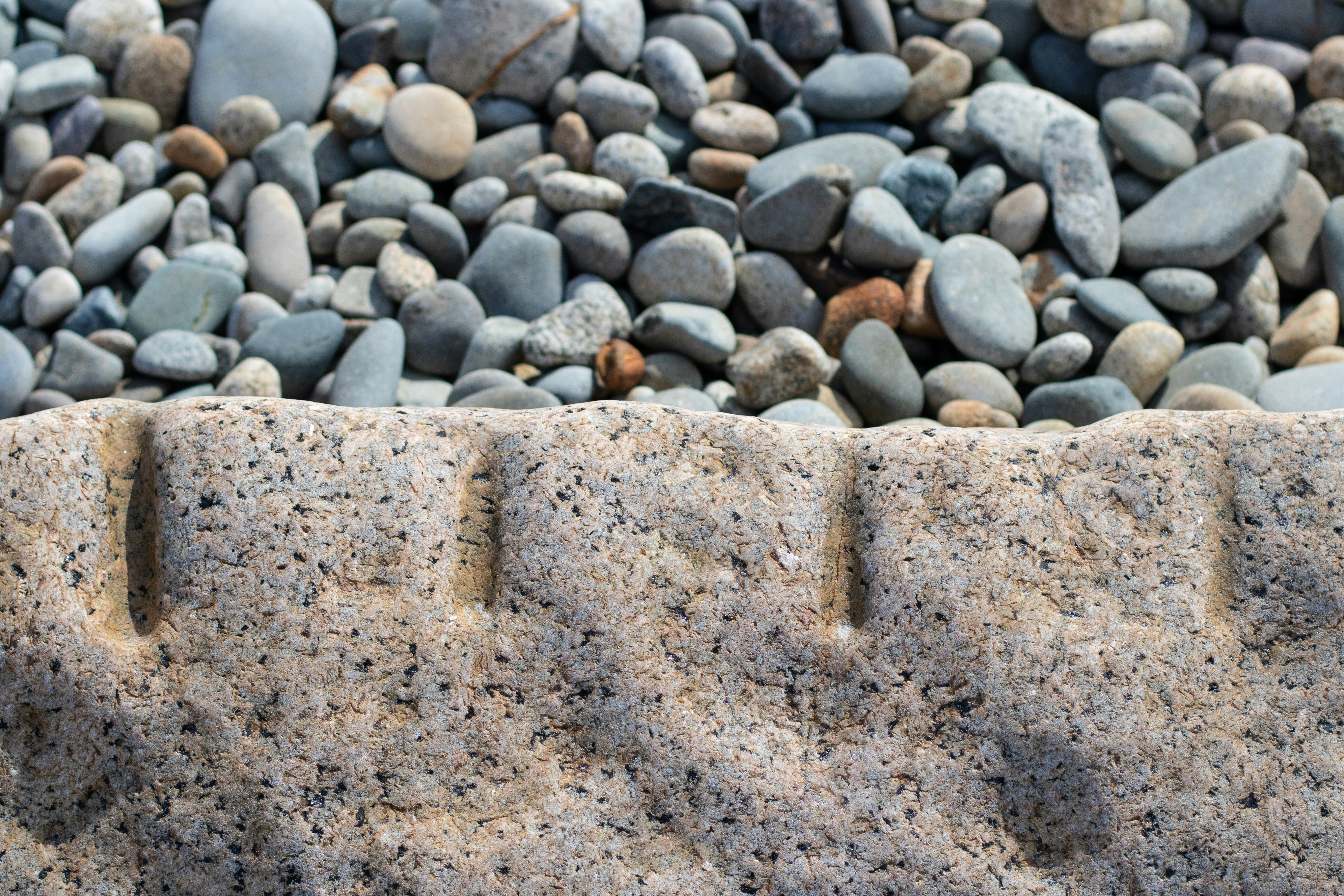 Pebble Beach Ripples: A Close-Up of Weathered Concrete and Gravel