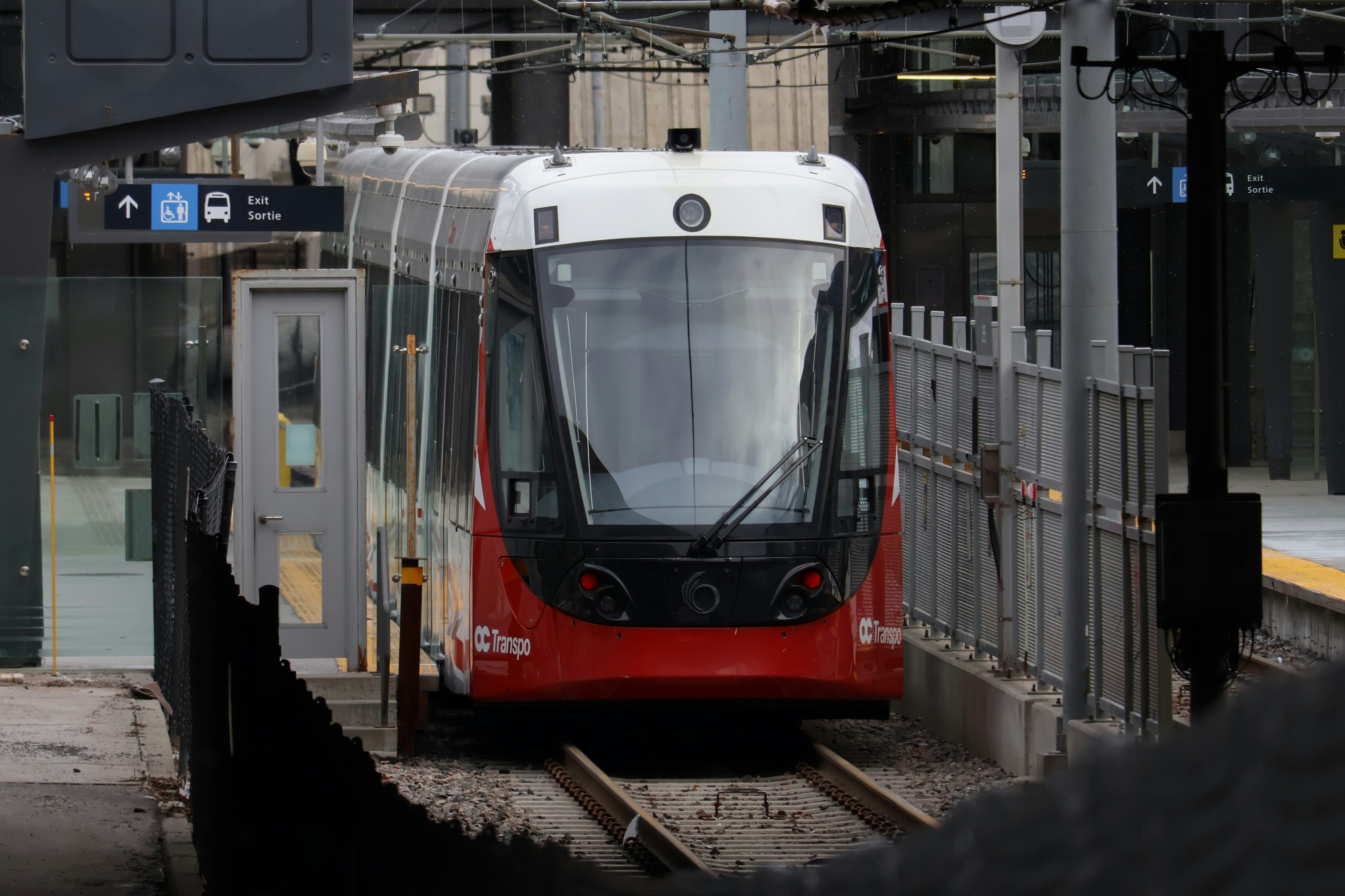 Front-on tram emerging from a city station tunnel