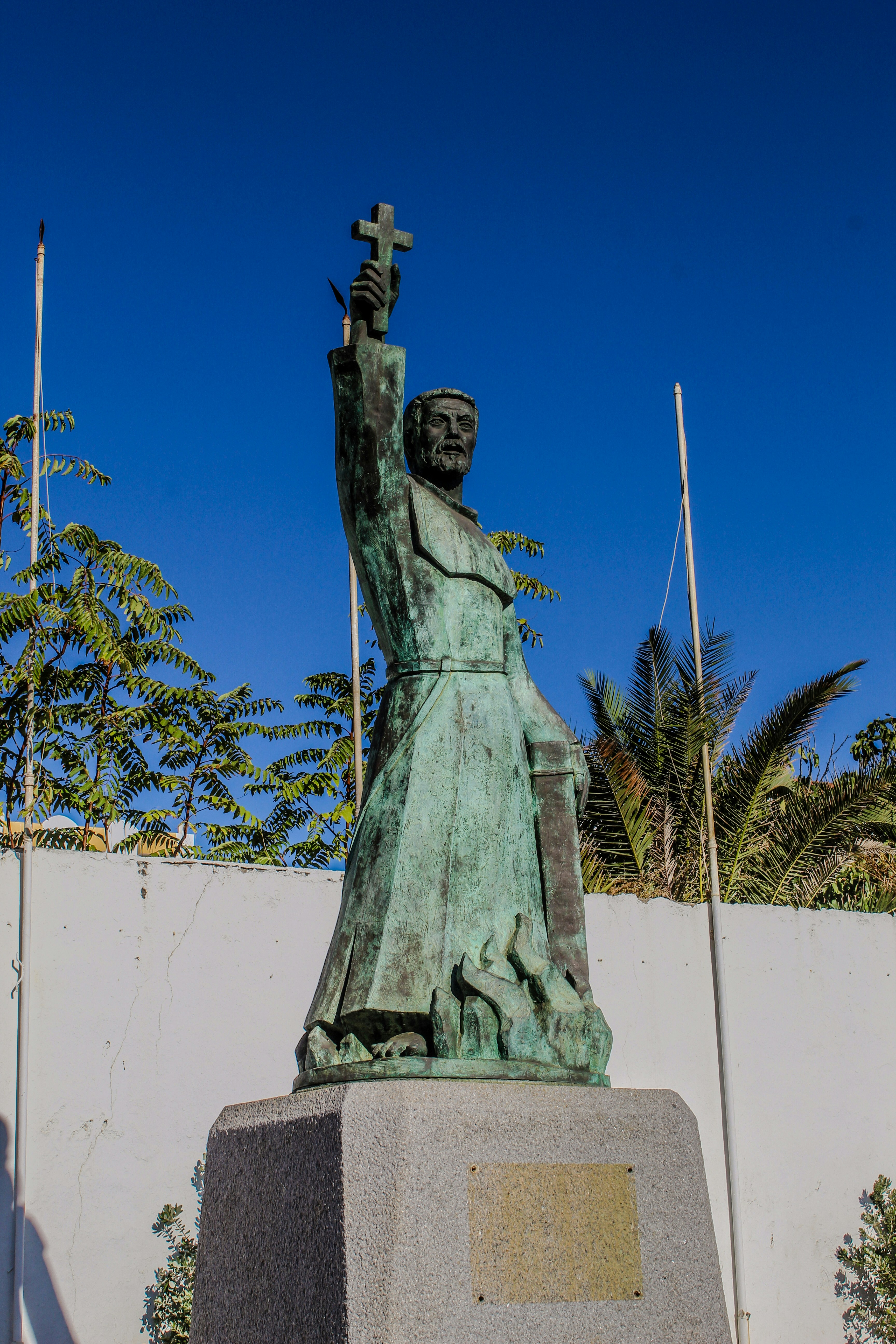 Bronze Crusader: A Raised Cross Against a Clear Skies