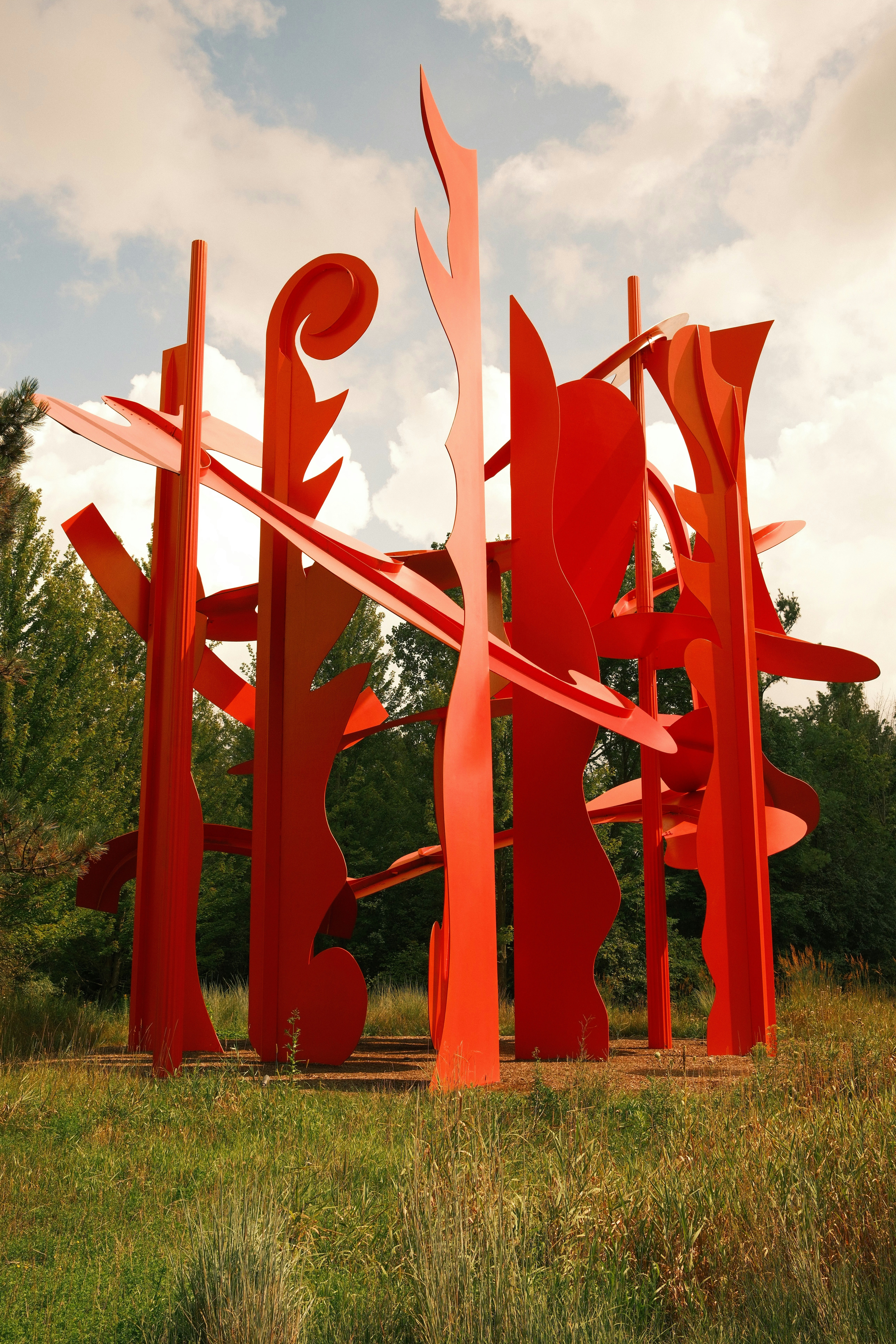 Crimson Echoes: Abstract Sculptures Reach Toward a Sky of Pines