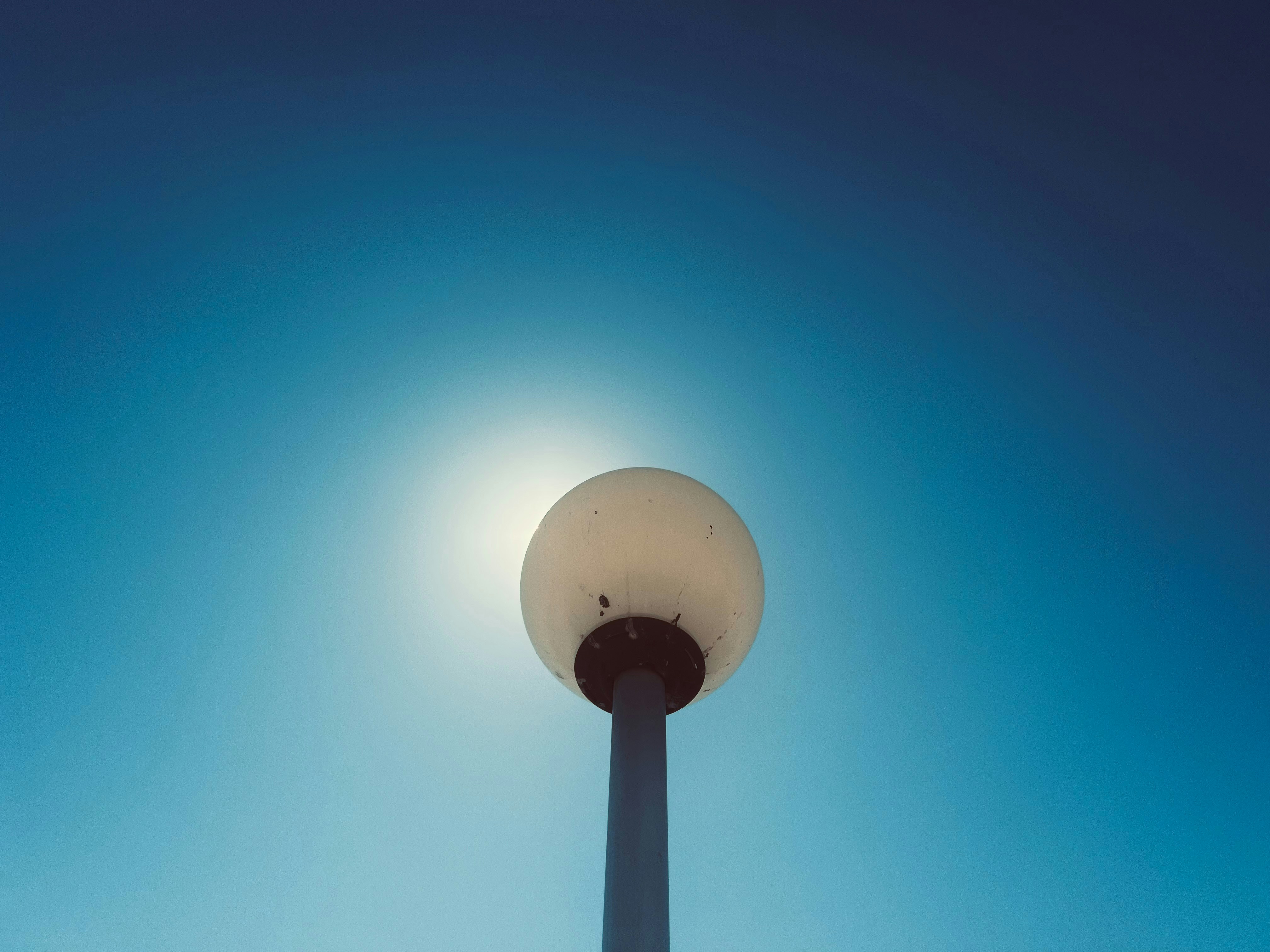 Moonlit Glow: a lone street lamp breaking through twilight