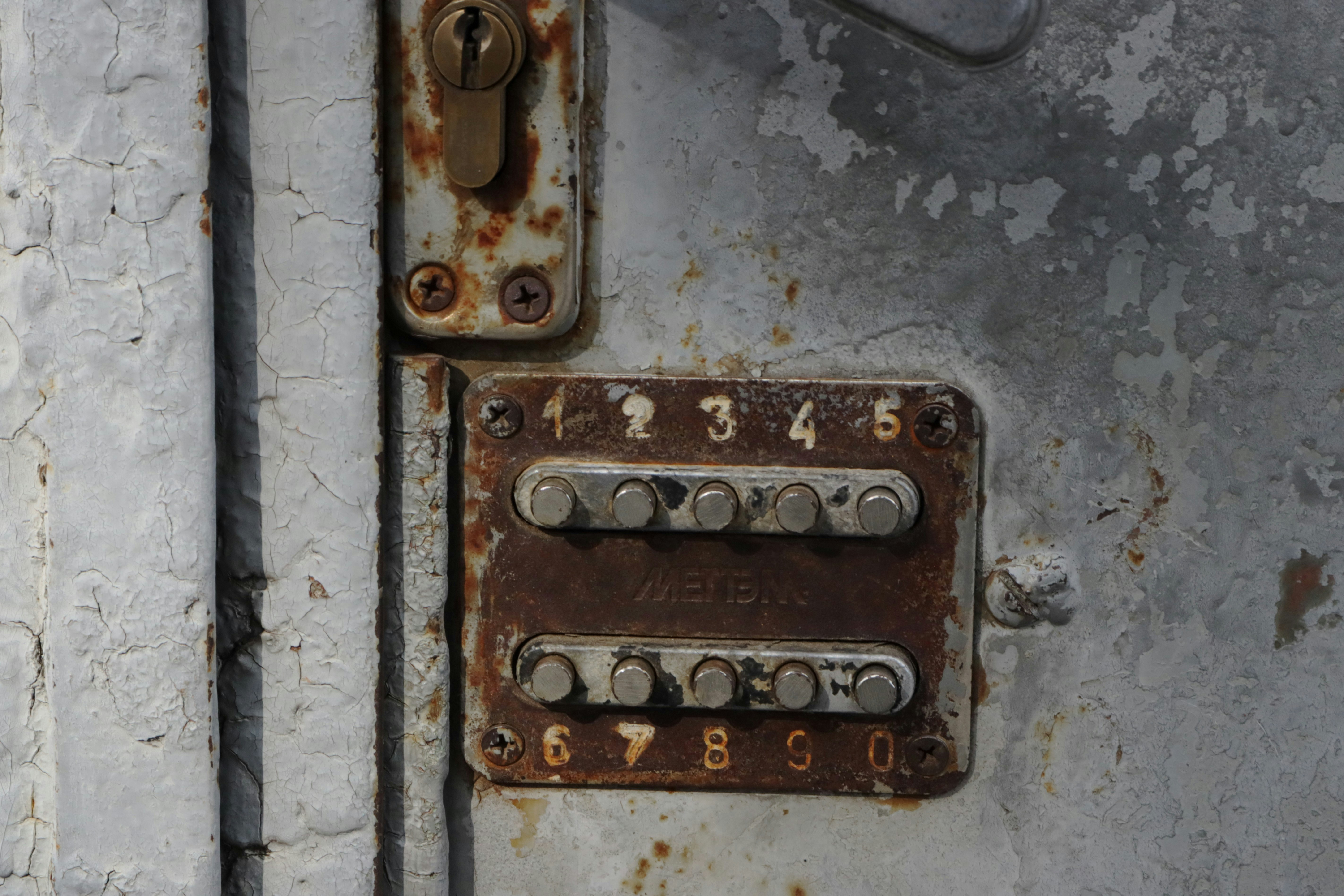 Rusted Safe Dial Gate: Timeworn Lock Mechanism on Weathered Metal