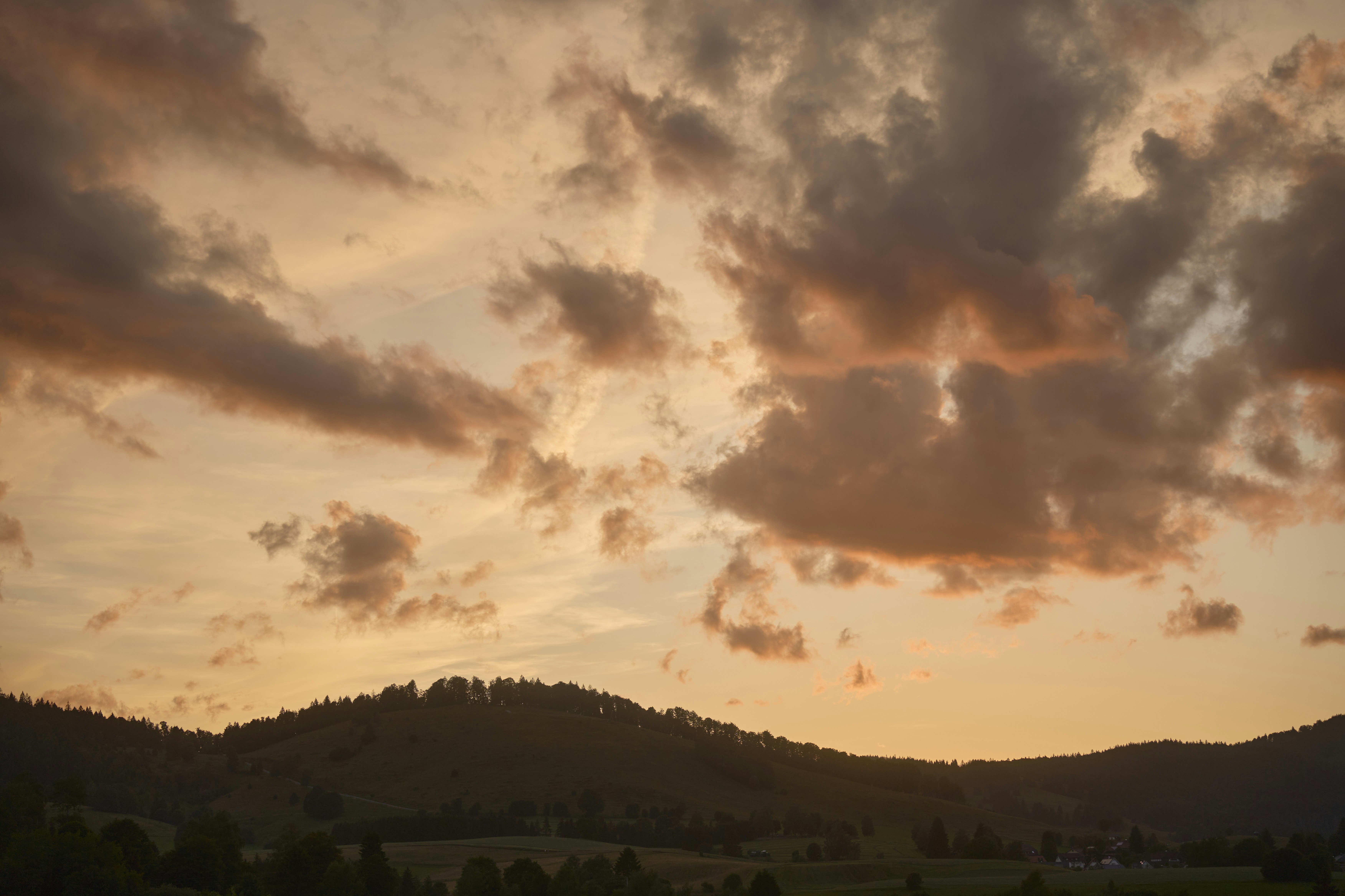 Horizon Fire: A Serene Sunset Over Rolling Hills