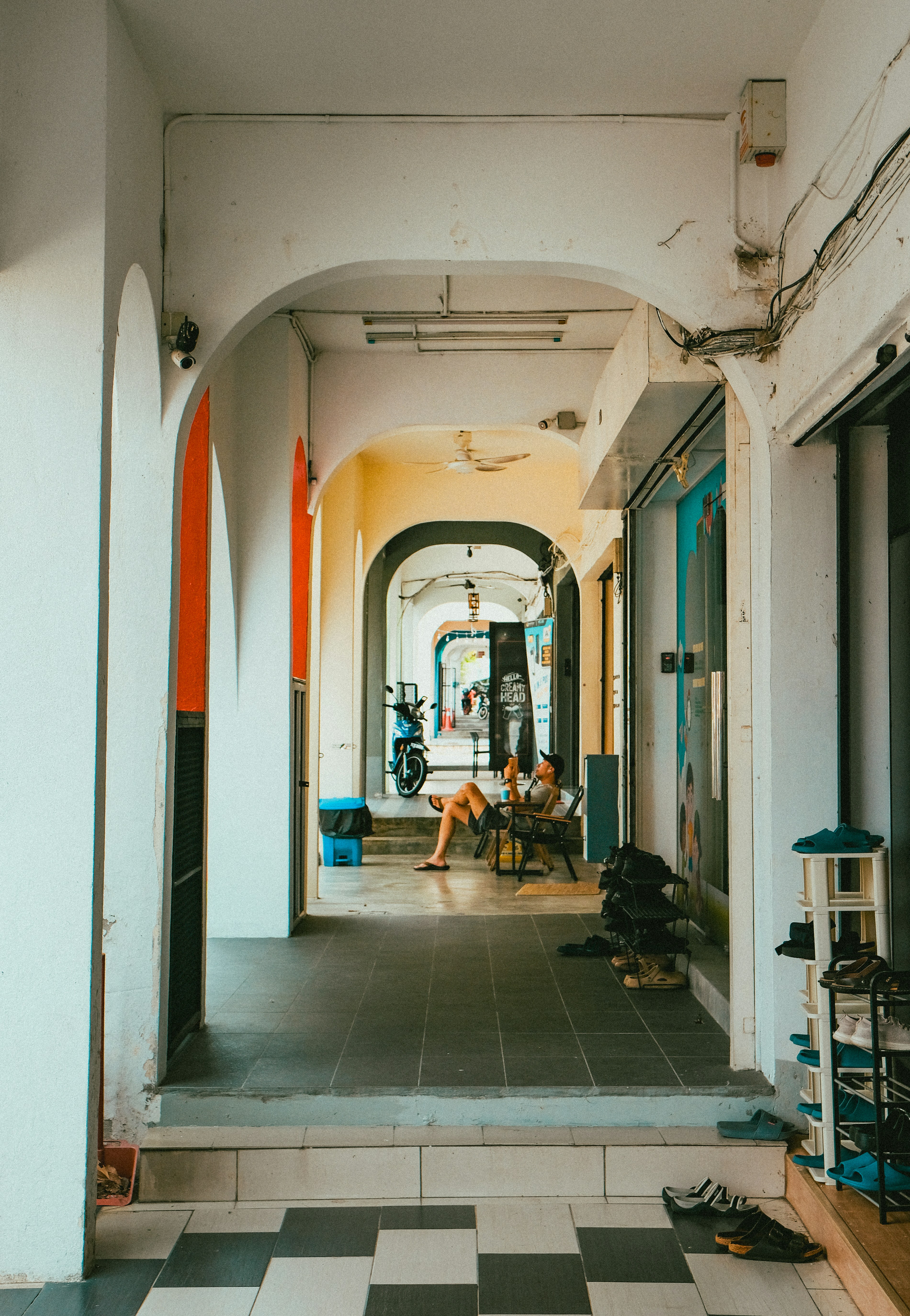 Arcade of Quiet Motion: A Shaded Corridor with People at Rest