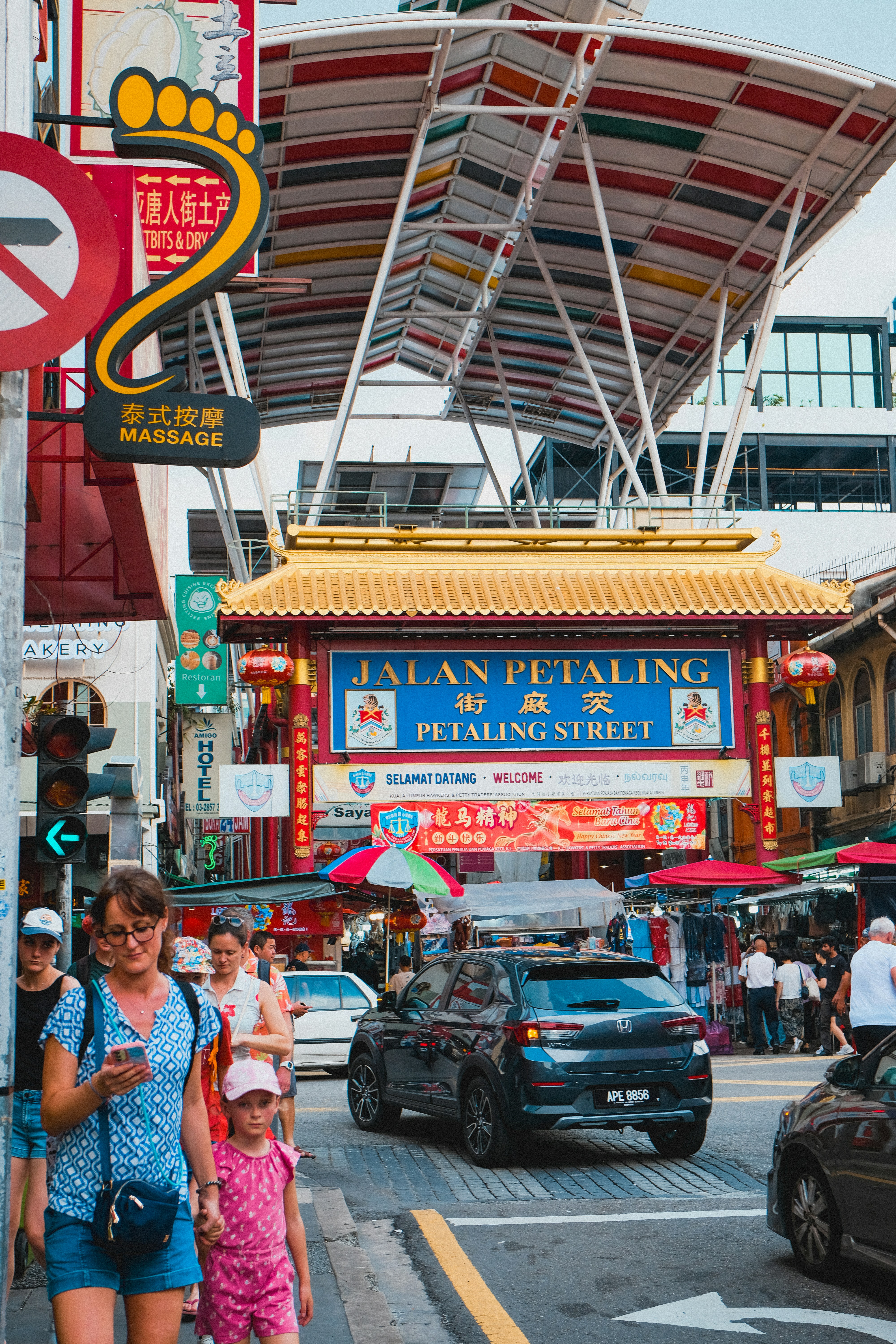 Petaling Street Gateway: Neon Sign, Temple Roof, and Street Market Bustle