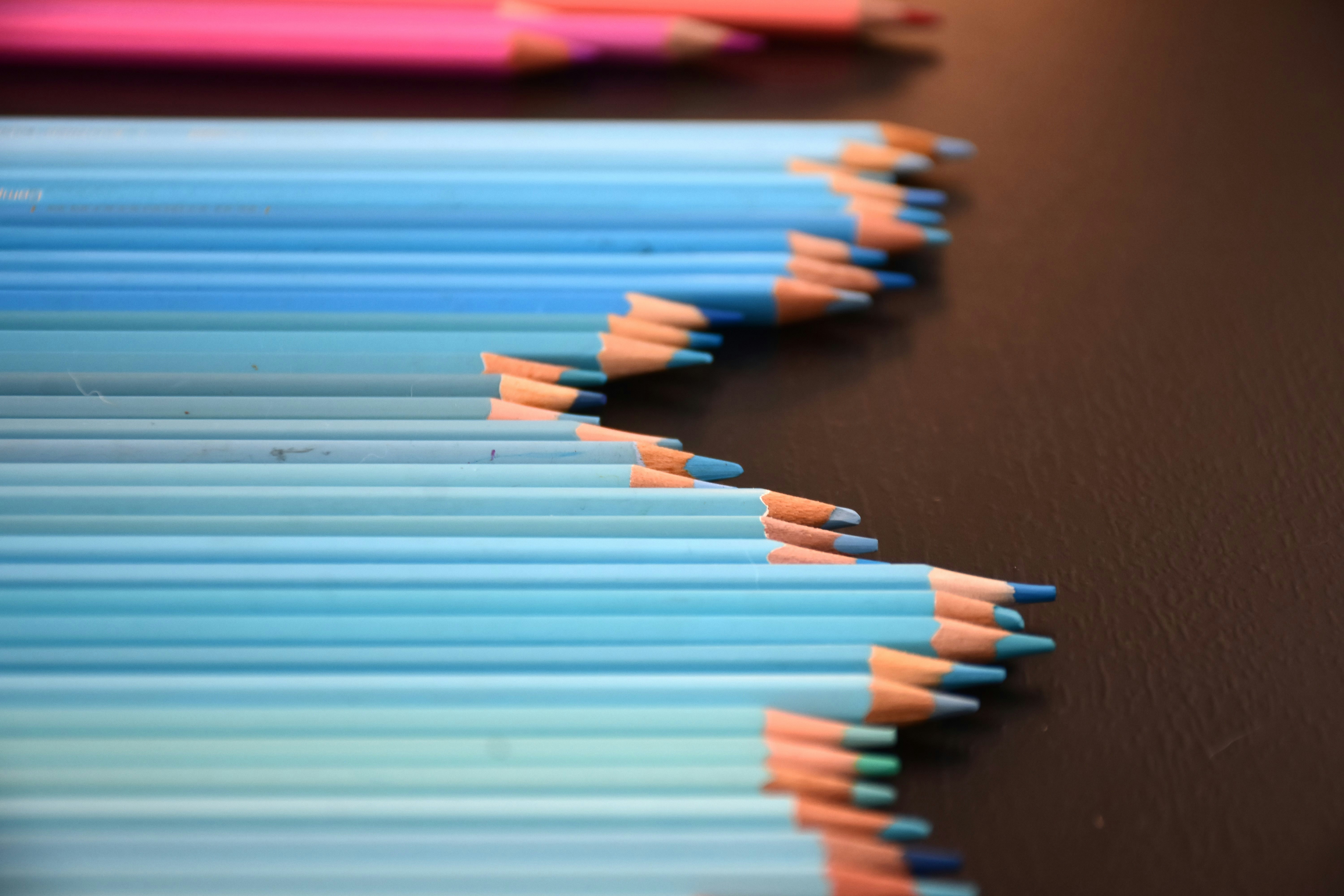 Hyperreal Rainbow of Worn Blue Pencils on a Dark Desk Edge