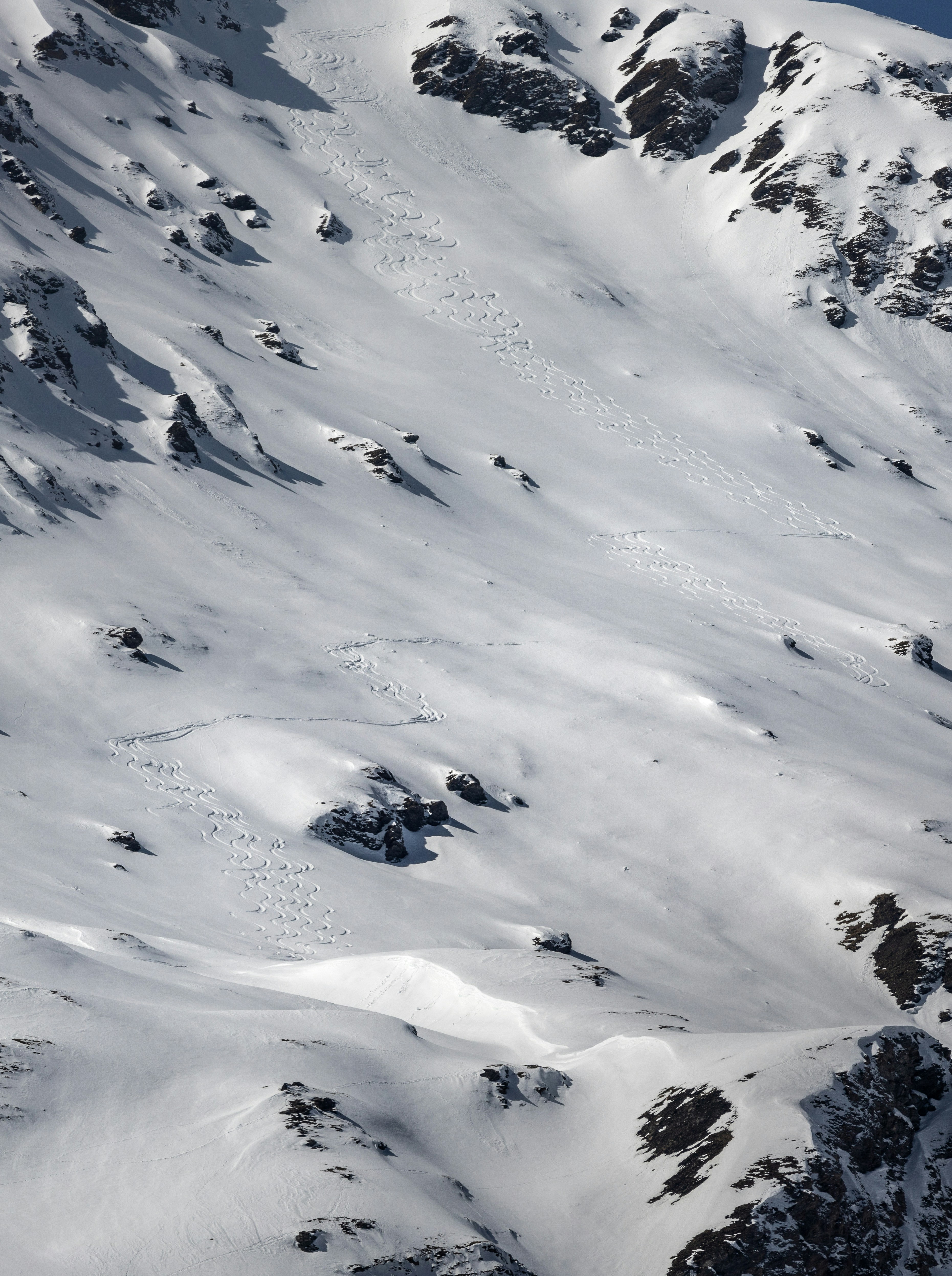 Snowbound Switchback: A Quiet Line of Tracks Across a Mountain Slope