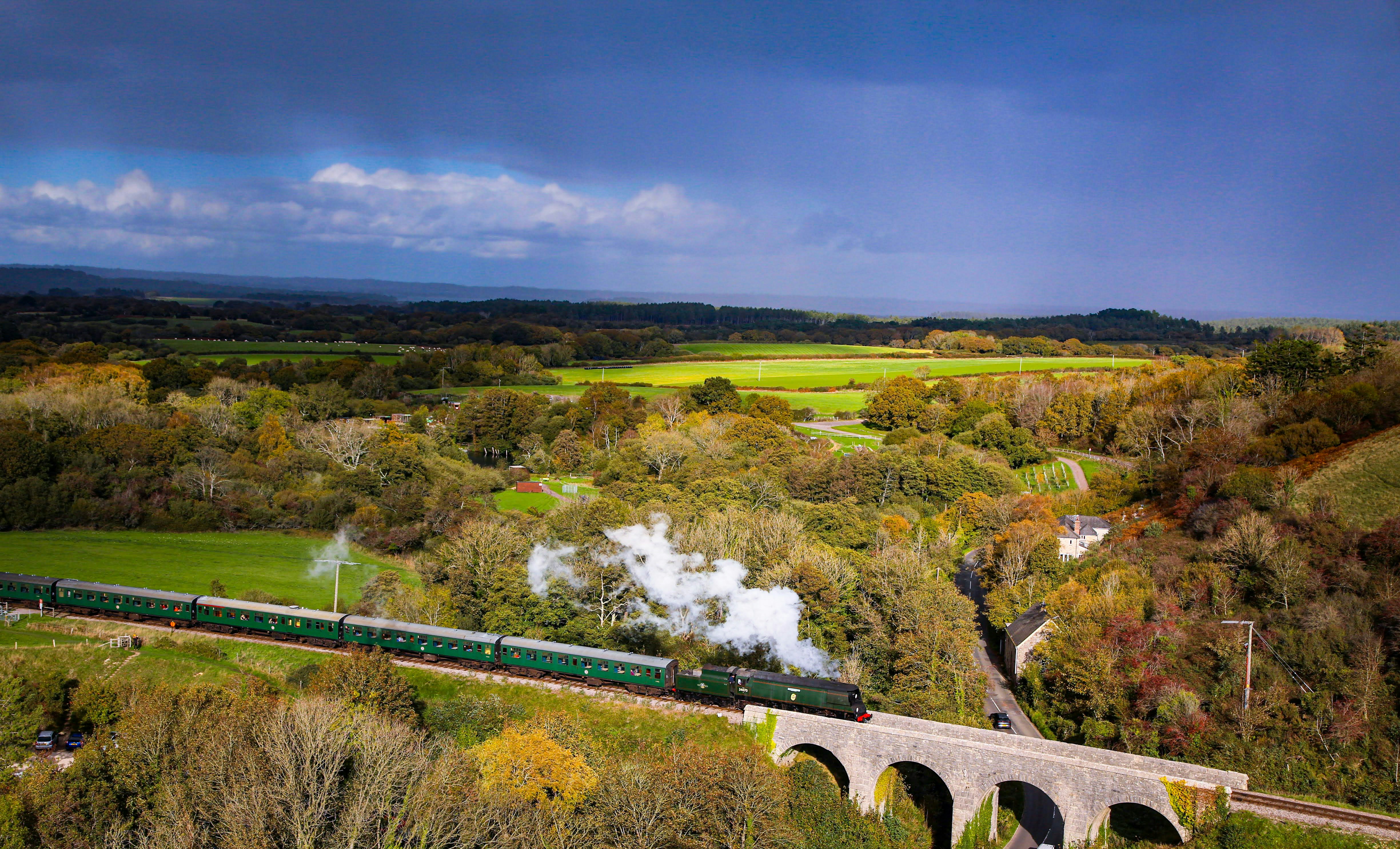 Steam over the viaduct: a green valley under a rolling sky