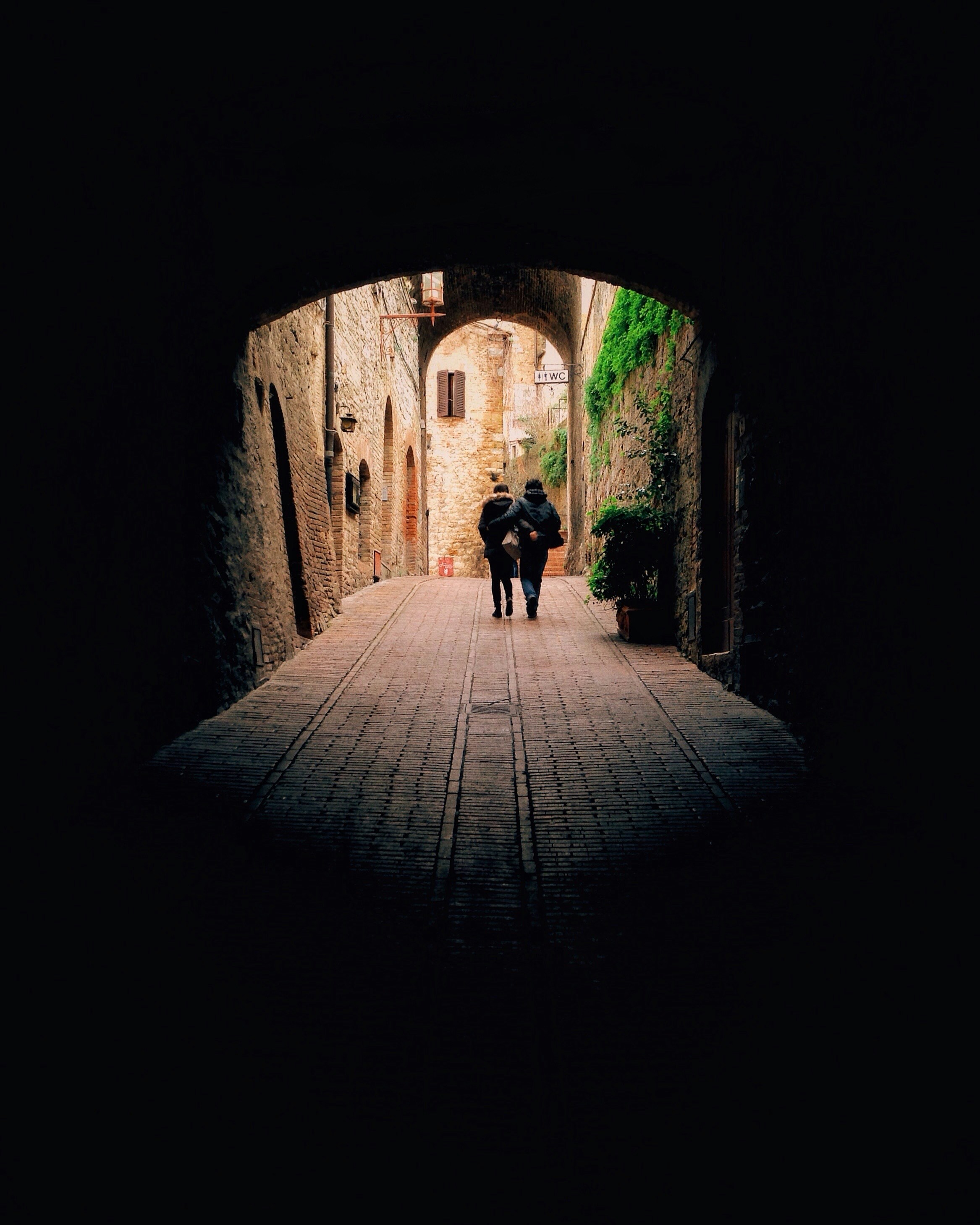 Toward the Light: A Quiet Calle in a Dim Arcaded Alley