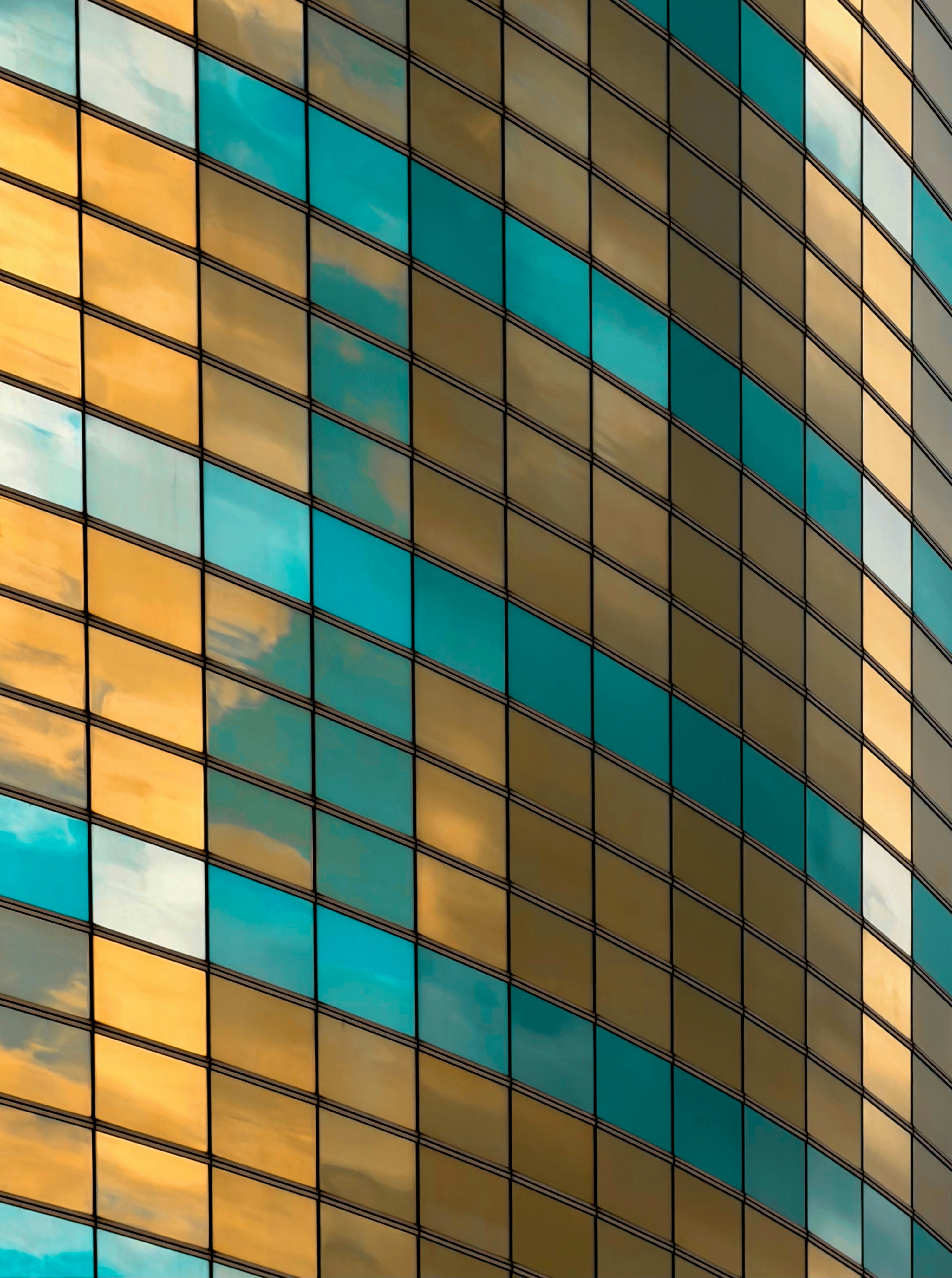 Diagonal Glass Facade in Sunlit Teal and Amber Grid