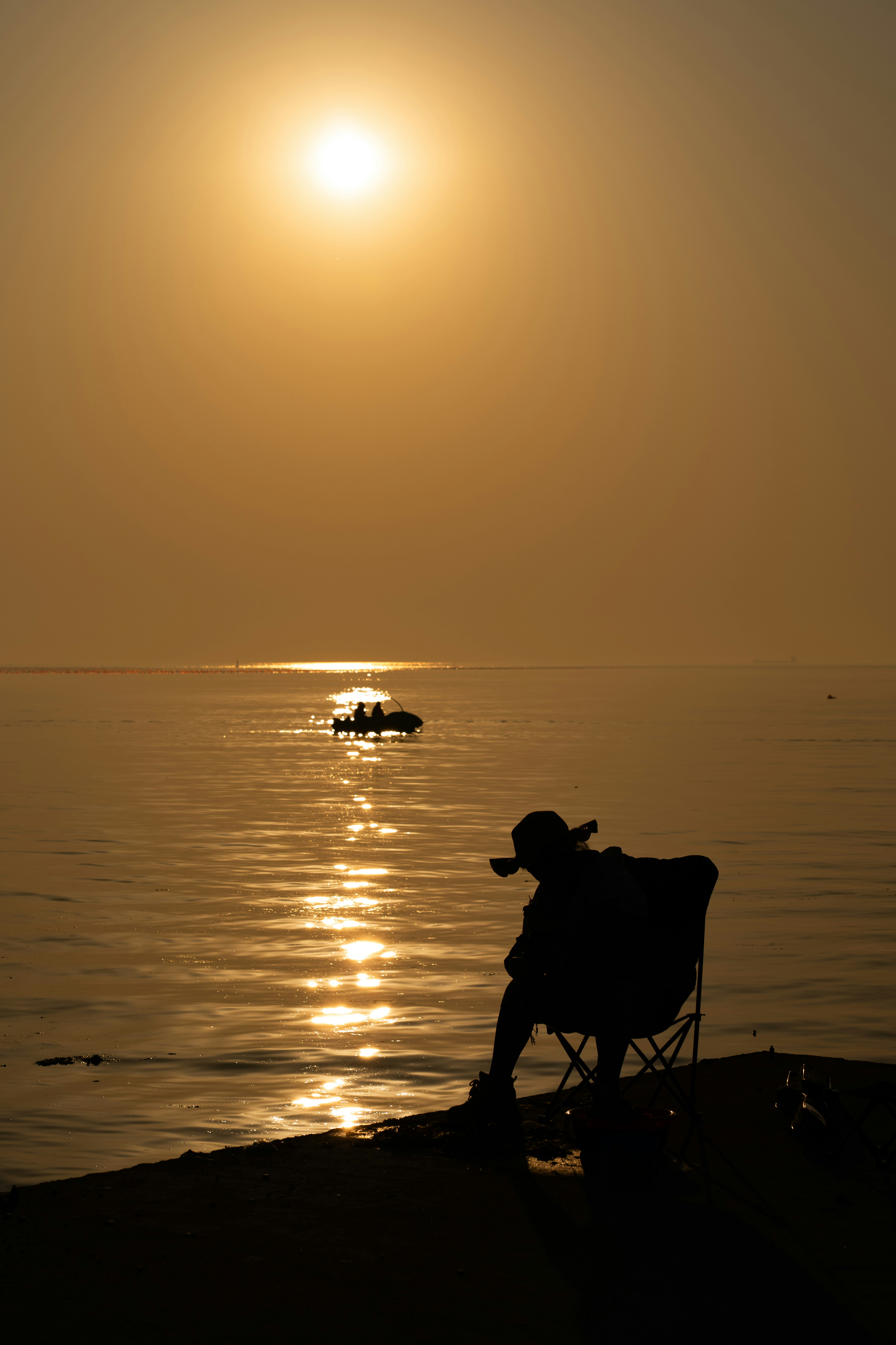 Silhouette at Sunset: A Fisherman’s Quiet Moment on the Shore