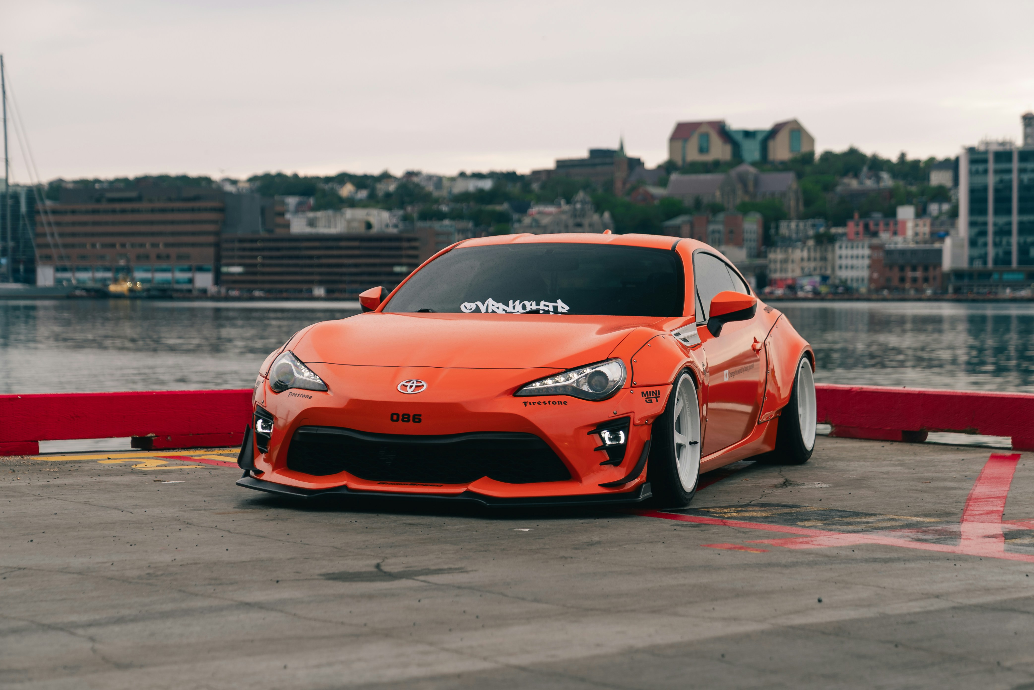 Midnight Flame on the Wharf: Orange Sports Car Anchors the Dockfront