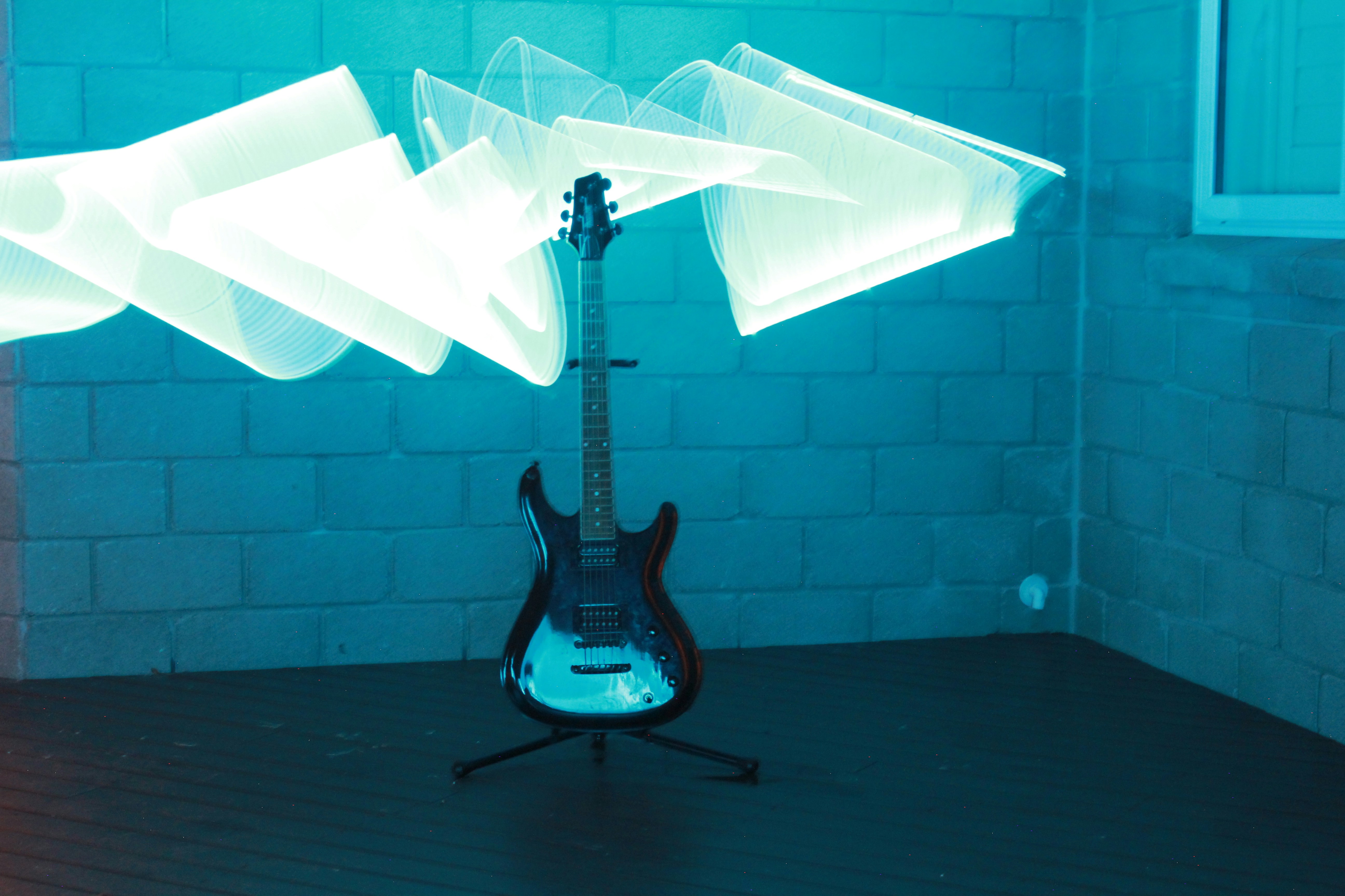 Guitars in Motion: A Neon Trace Across a Quiet Studio