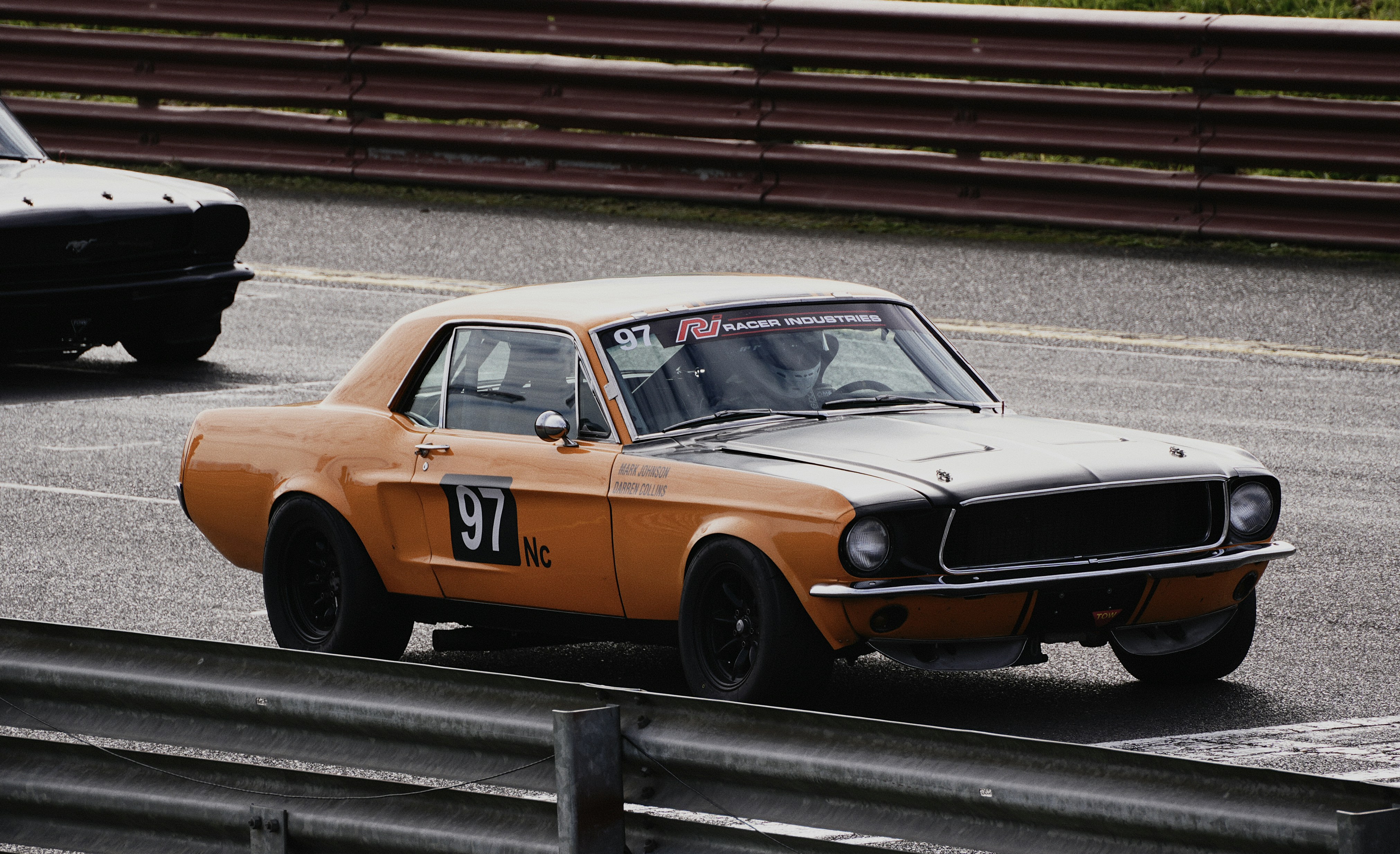 Orange racing heritage: vintage muscle car claws through wet track