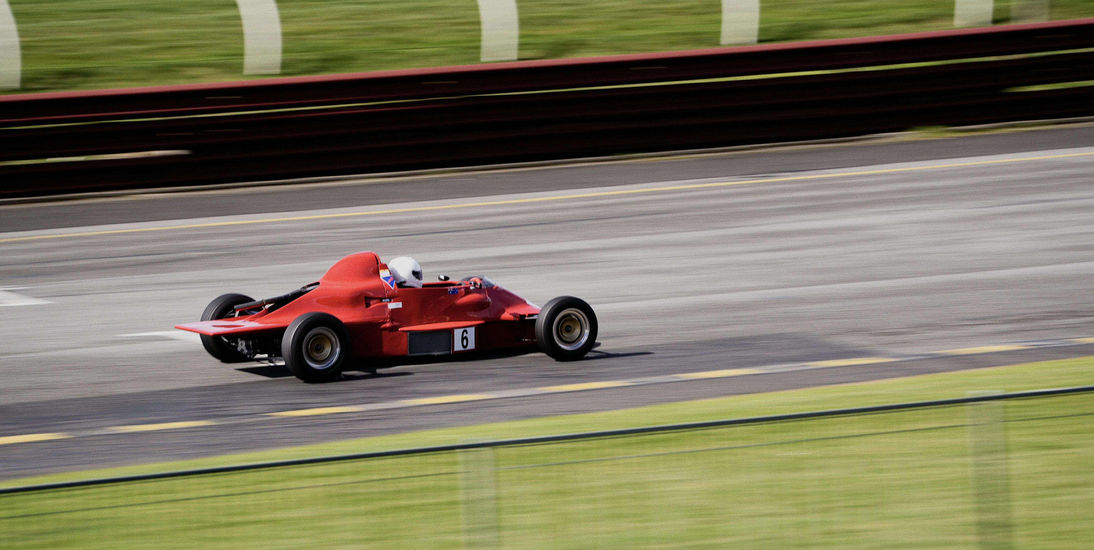 Red Formula Car in Motion: Focused Sprint on the Track