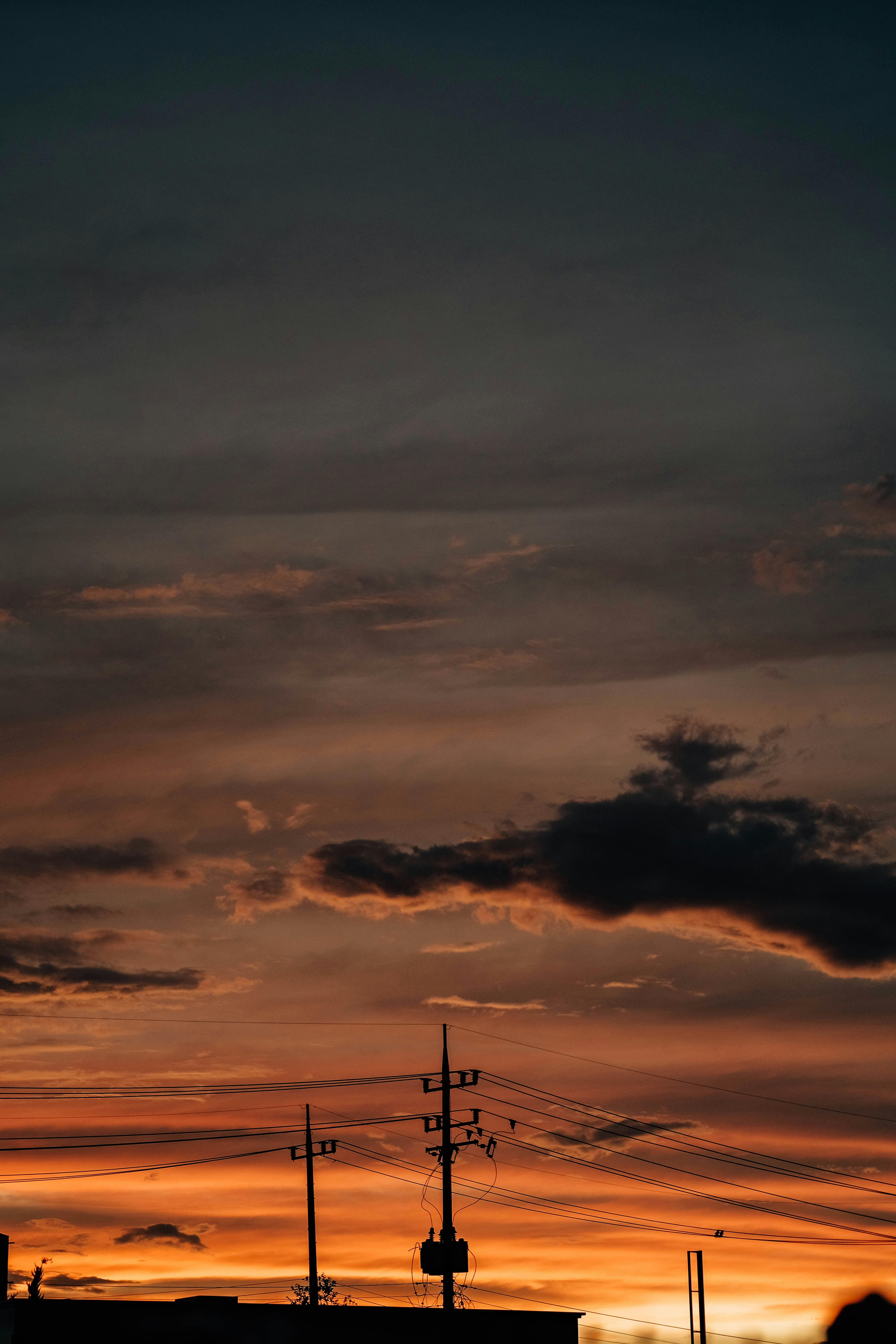 Silhouetted Skyline at Sunset with Power Lines