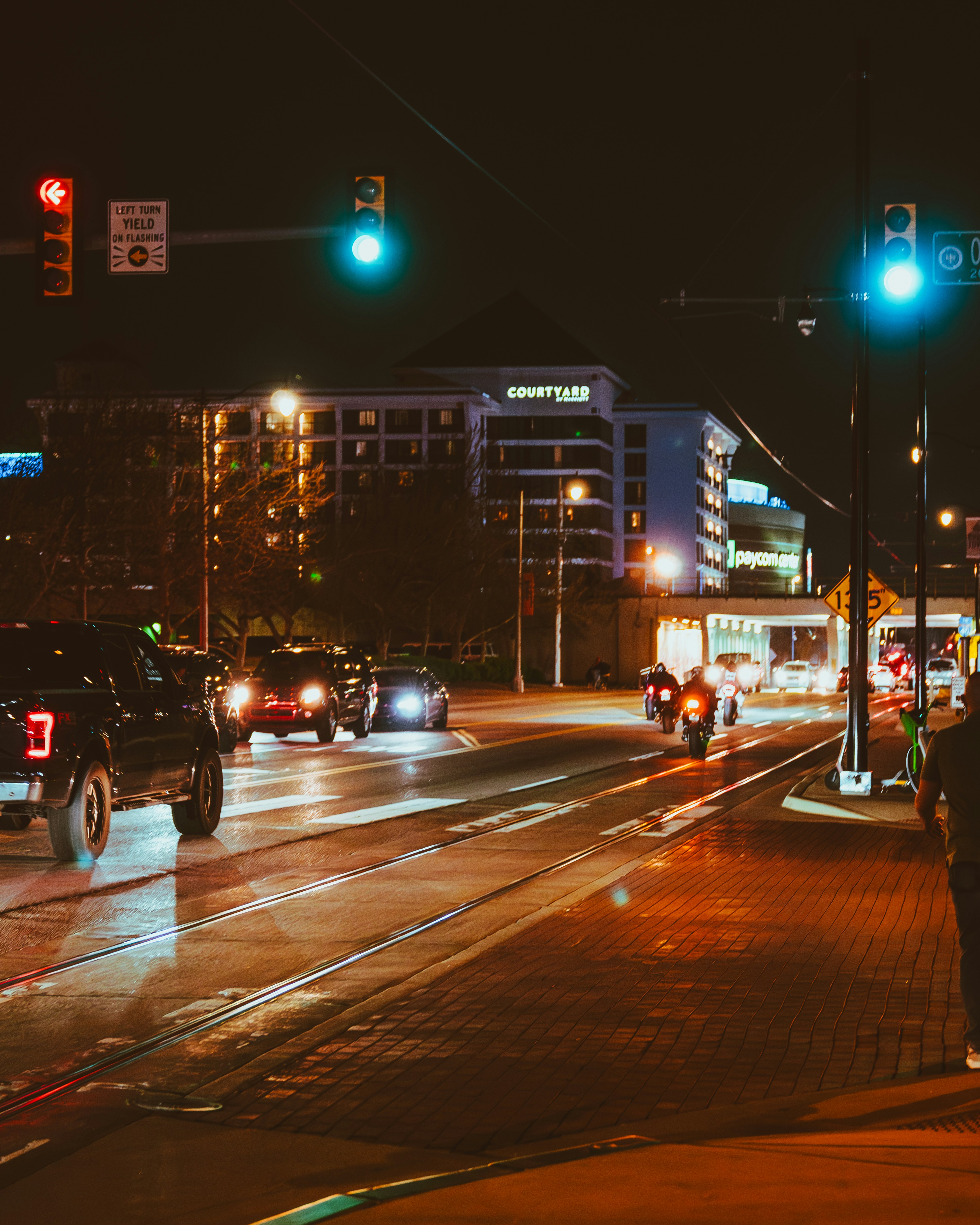 Night Courtyard: Neon Traffic and Wet Brick Streets