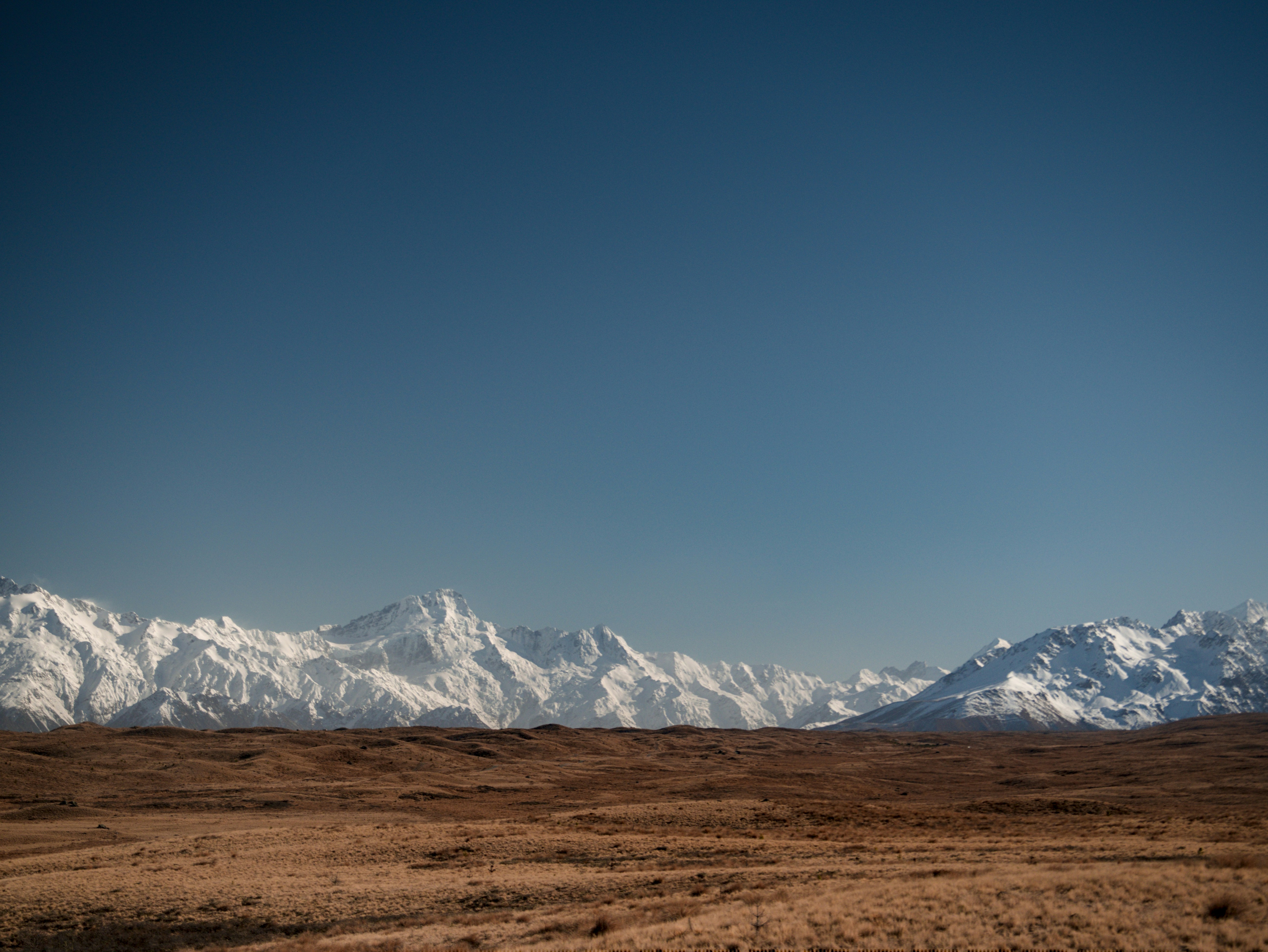 Bearing Witness: Snow-Crowned Ridge Across a Flat Moor