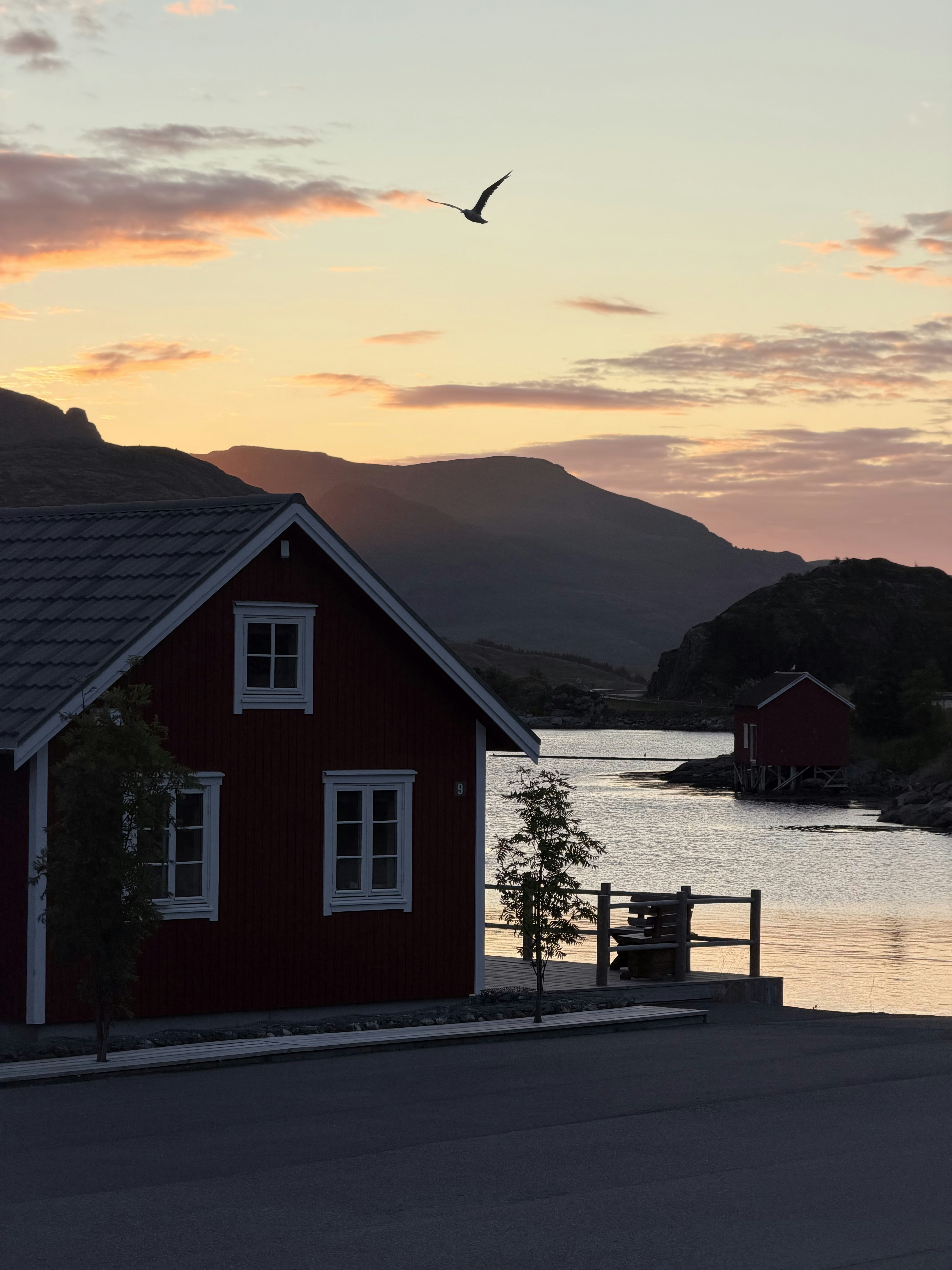 Red Cabin by the Quiet Fjord at Sunset