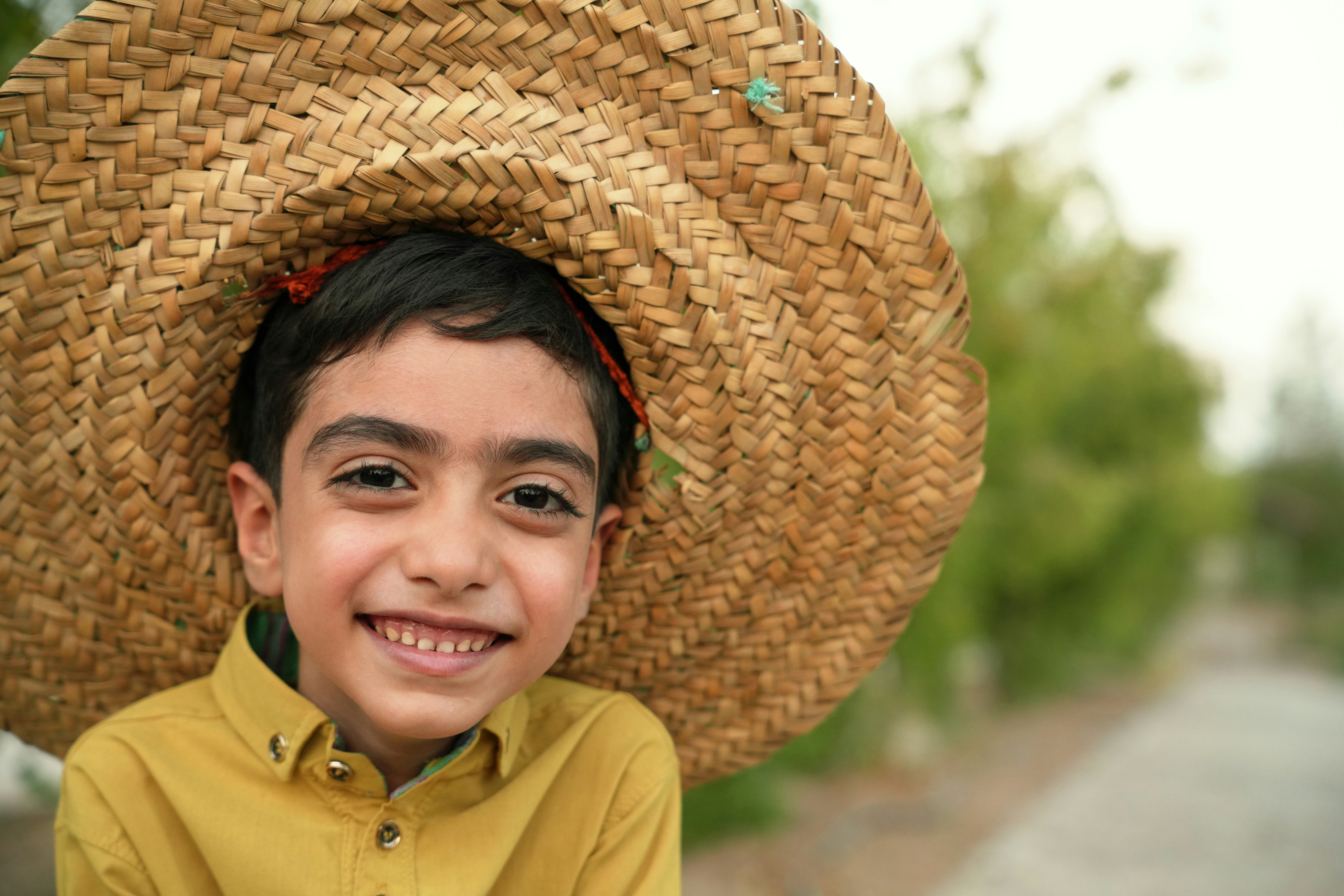 Smiling Explorer in a Looming Straw Hat