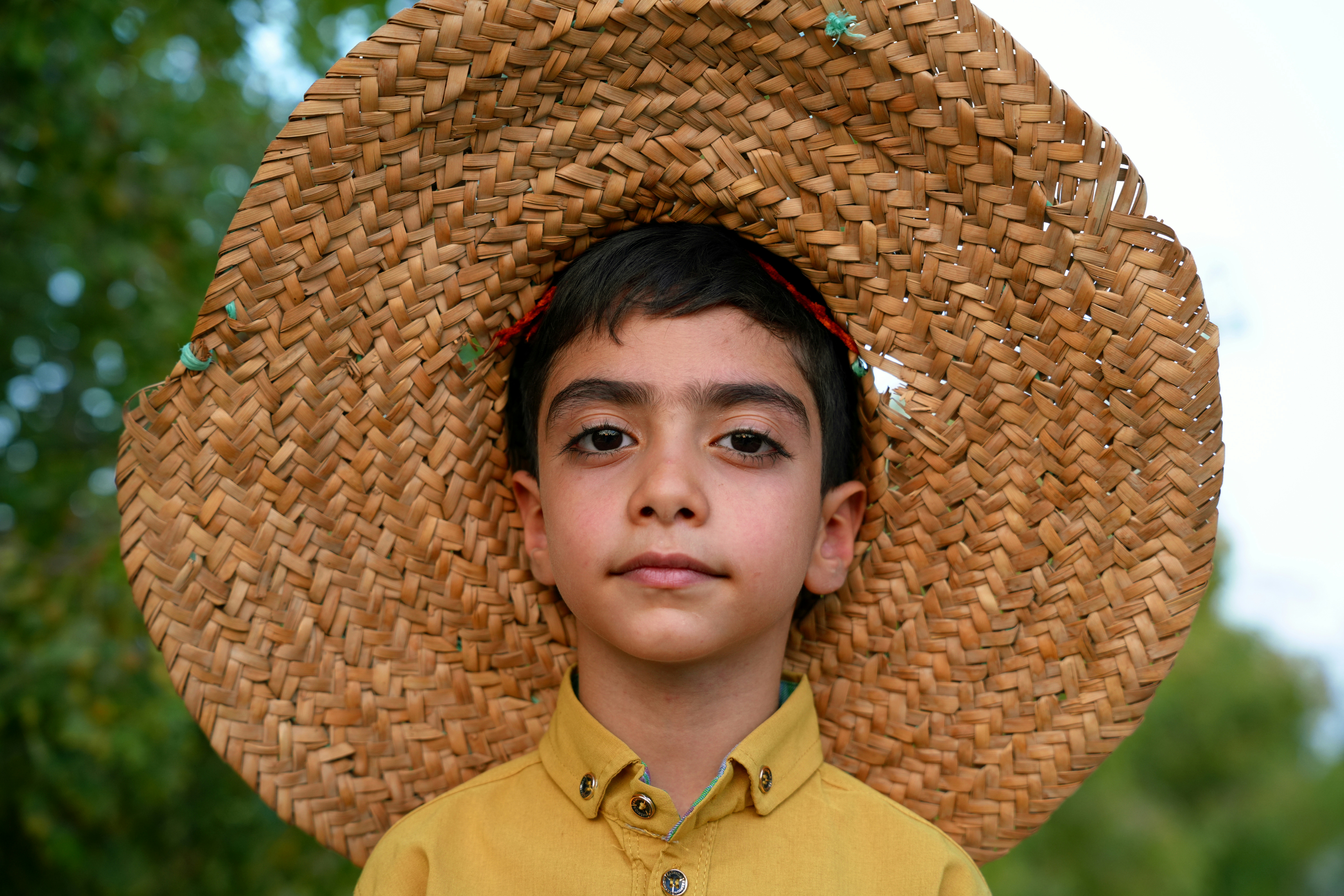 Straw Hat Portrait: A Quiet Gaze Under Wide Brim