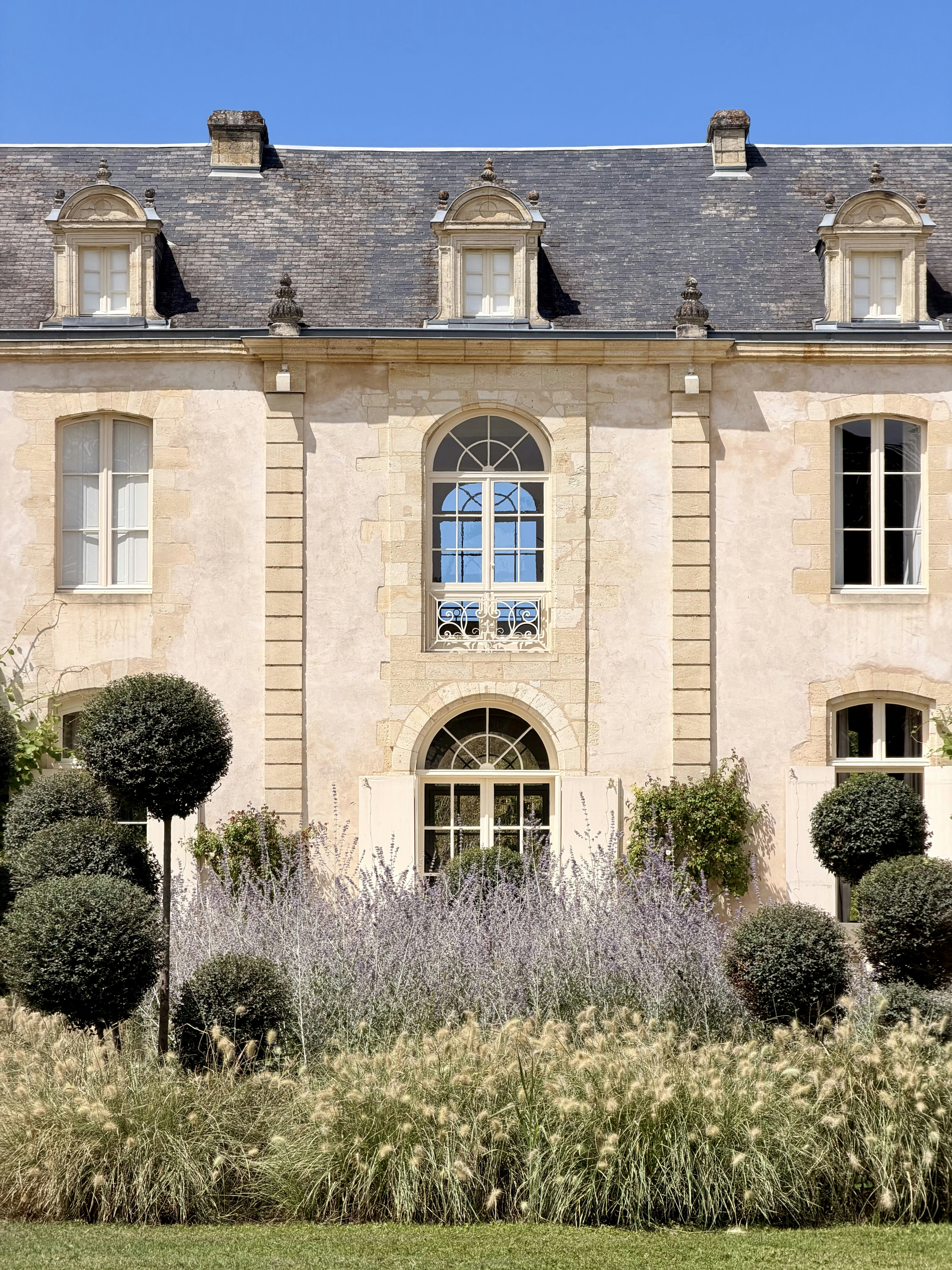 Symmetrical Manor Facade Framed by Lavender and Topiary