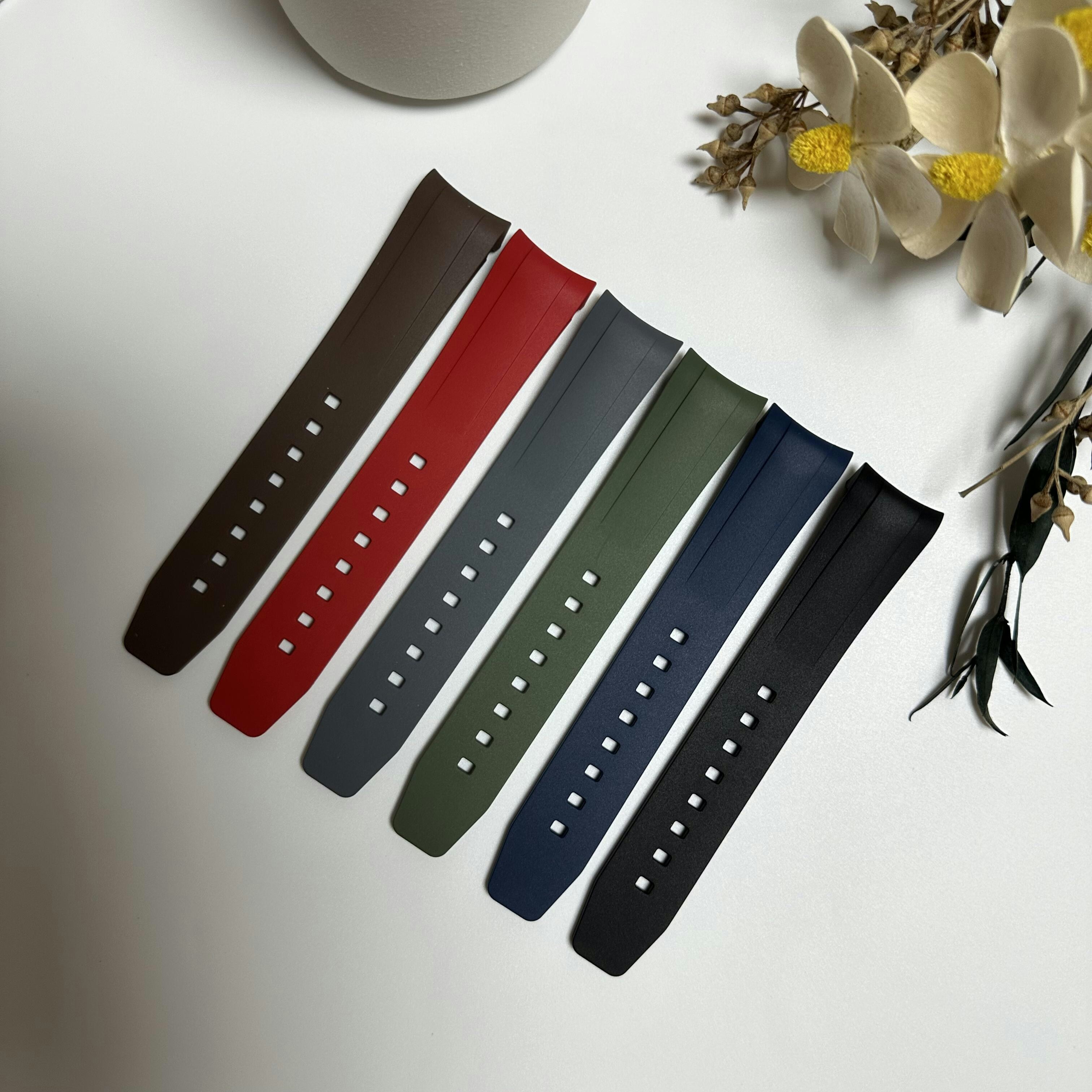 Chromatic Roll: A Row of Apple Watch Straps on a White Studio Surface