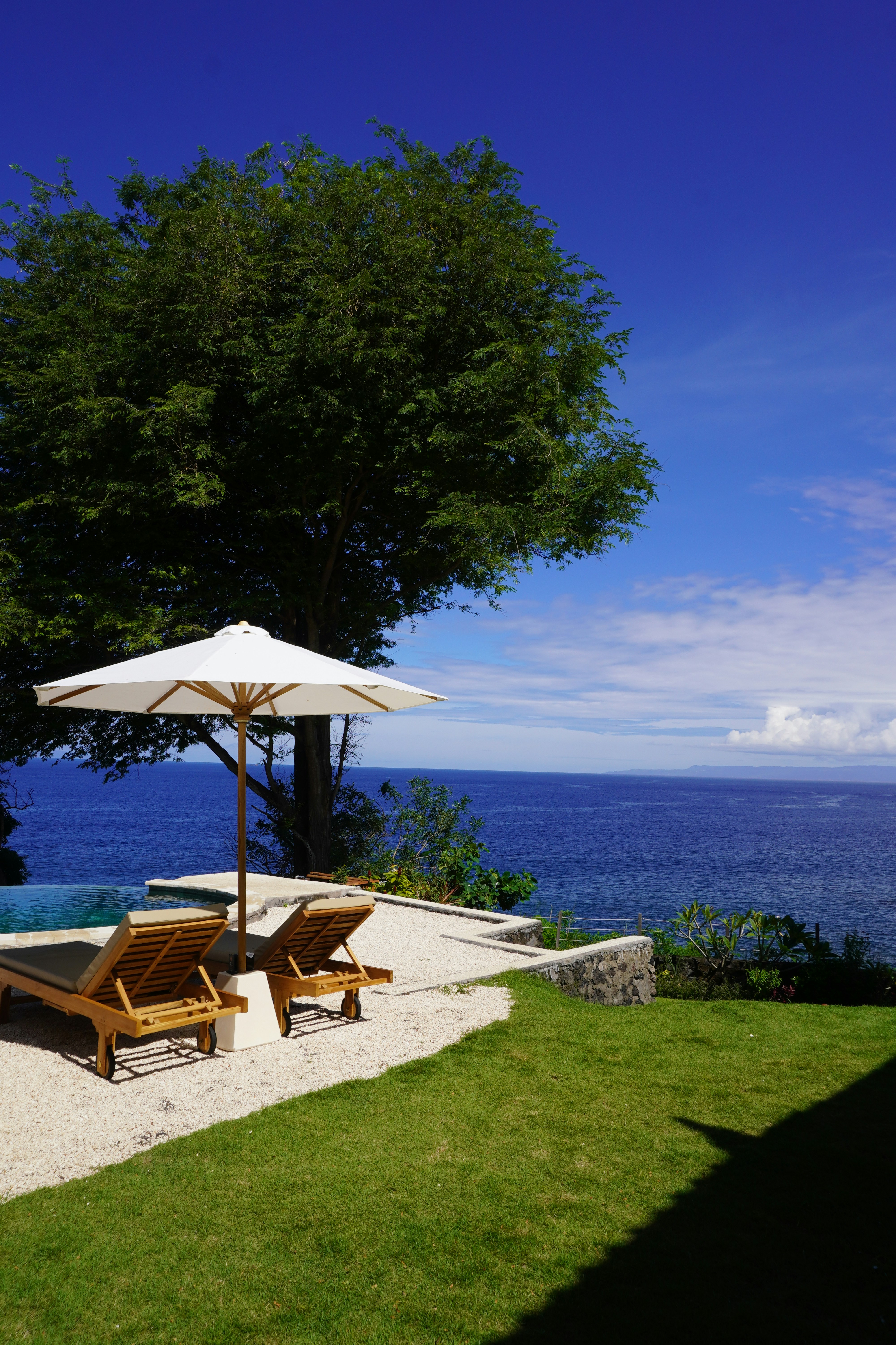 Coastal Terrace: Loungers, Umbrella, and Sea Blue Horizon
