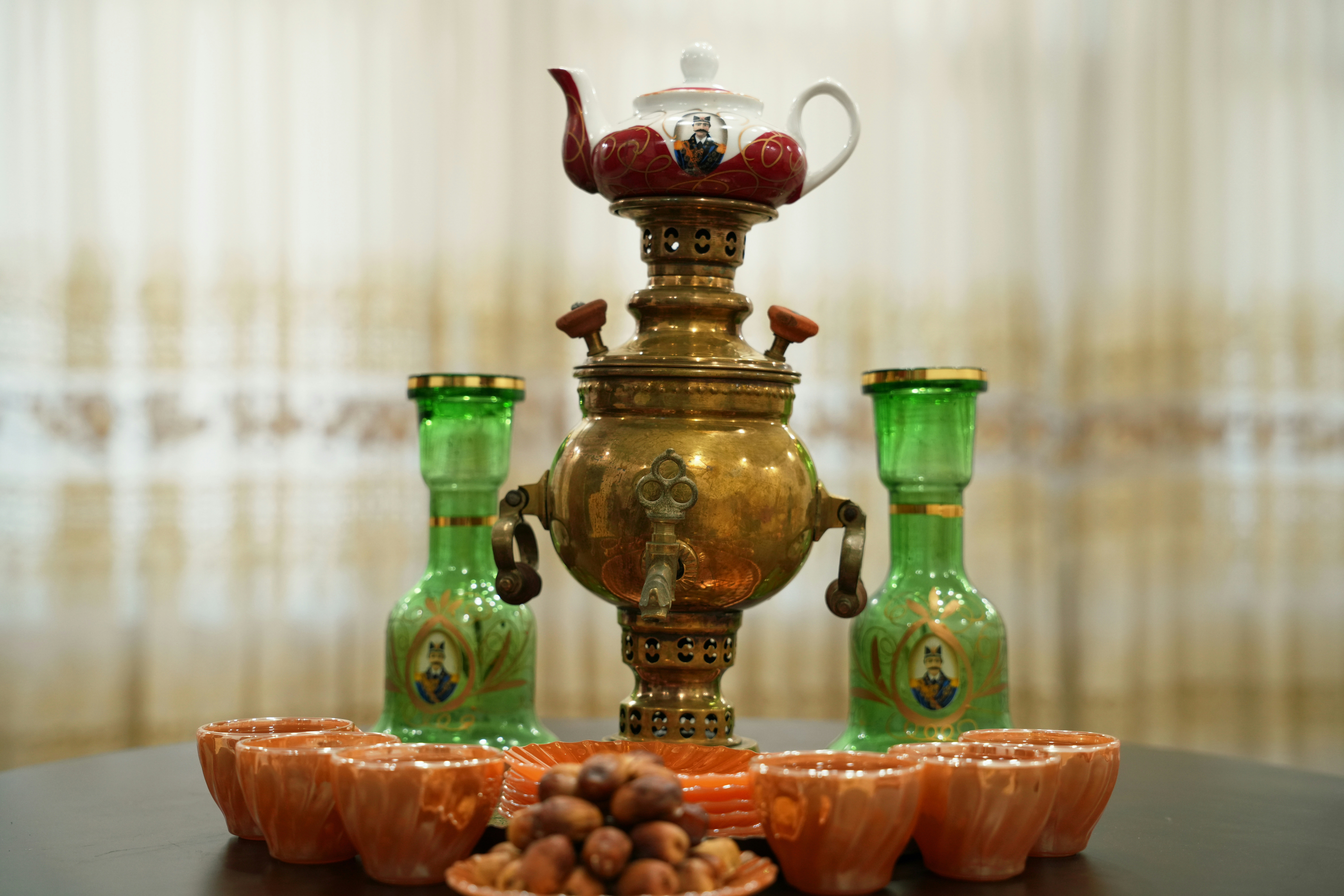 The Brass Altar: Tea Services and Olive Glasses Framing a Ceremonial Centerpiece
