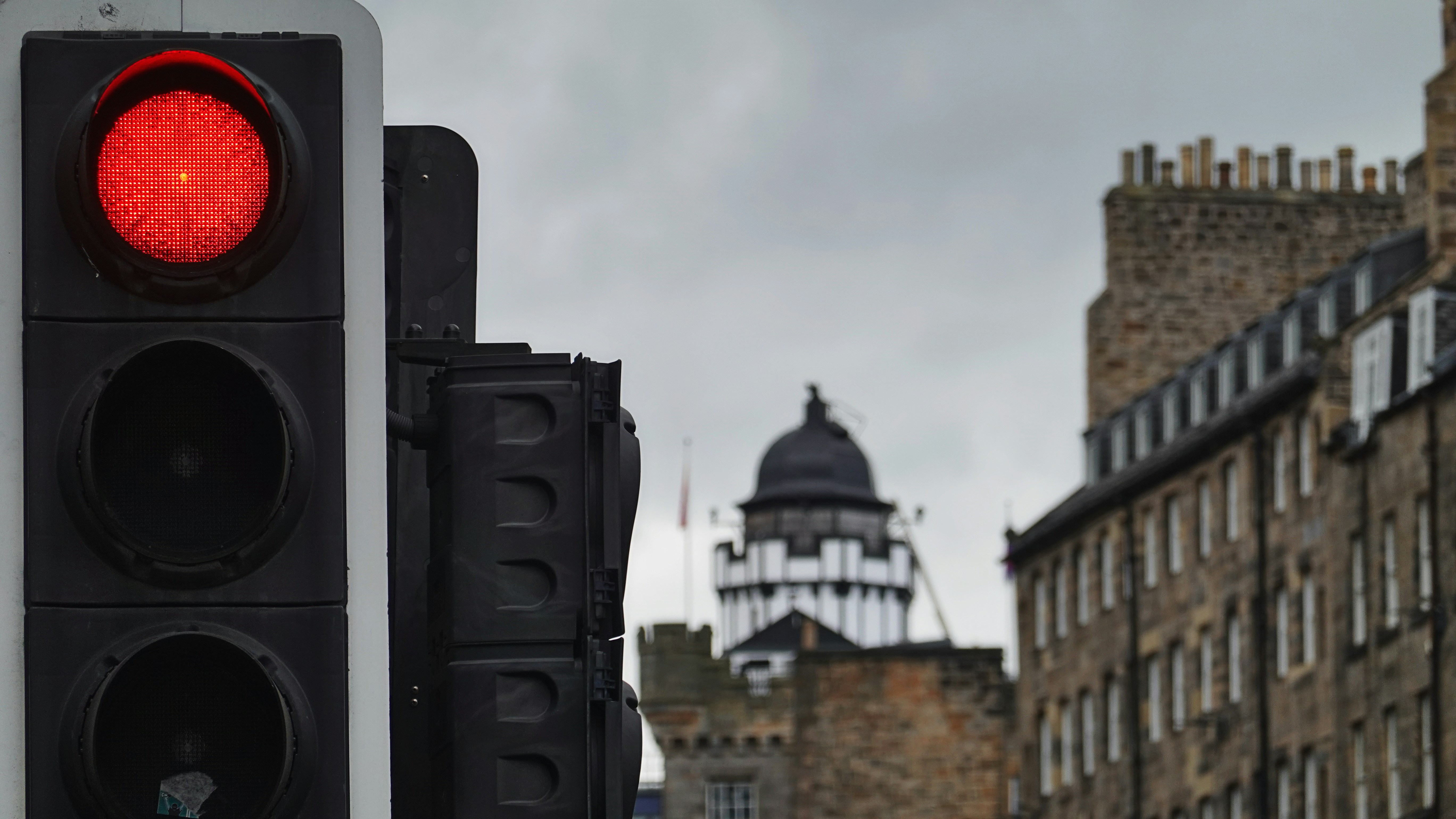 Red Signal, Quiet Street: A City Moment Framed by Architecture