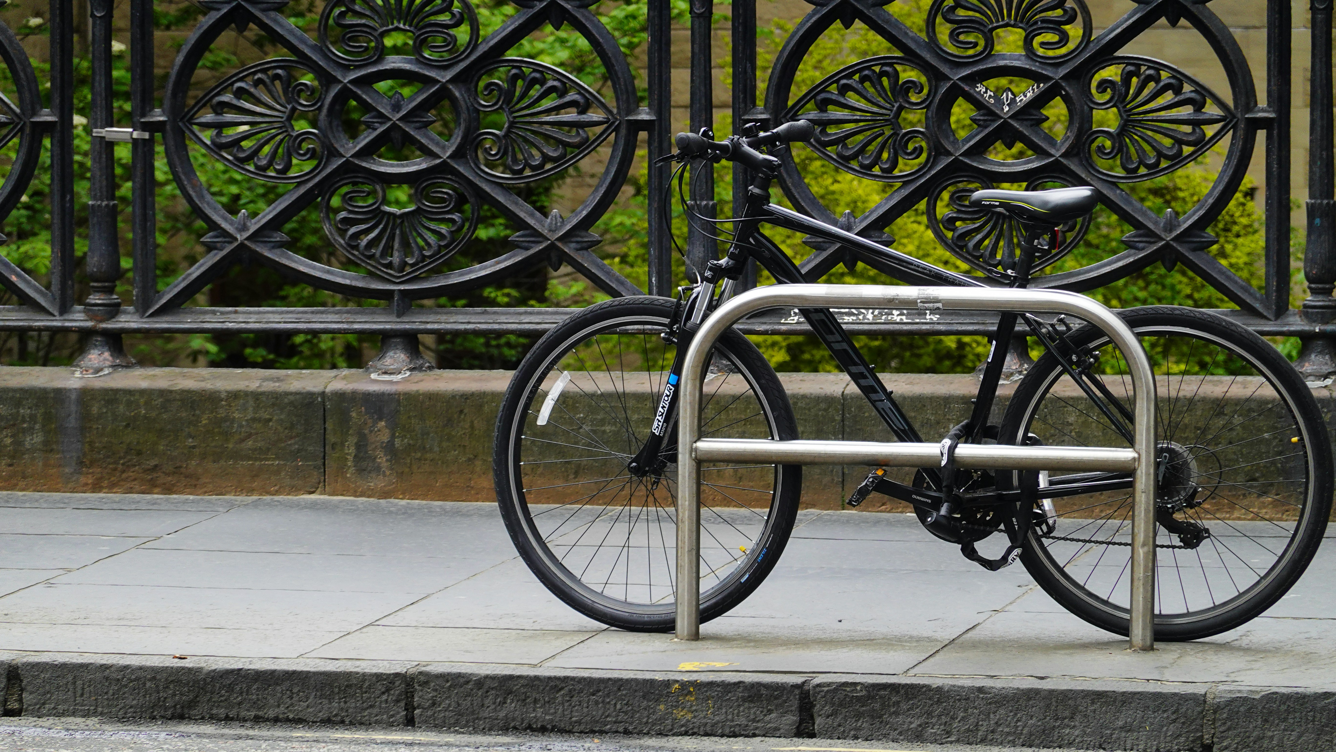Locked Steel: A City Bicycle Tethered to Ornate Railings