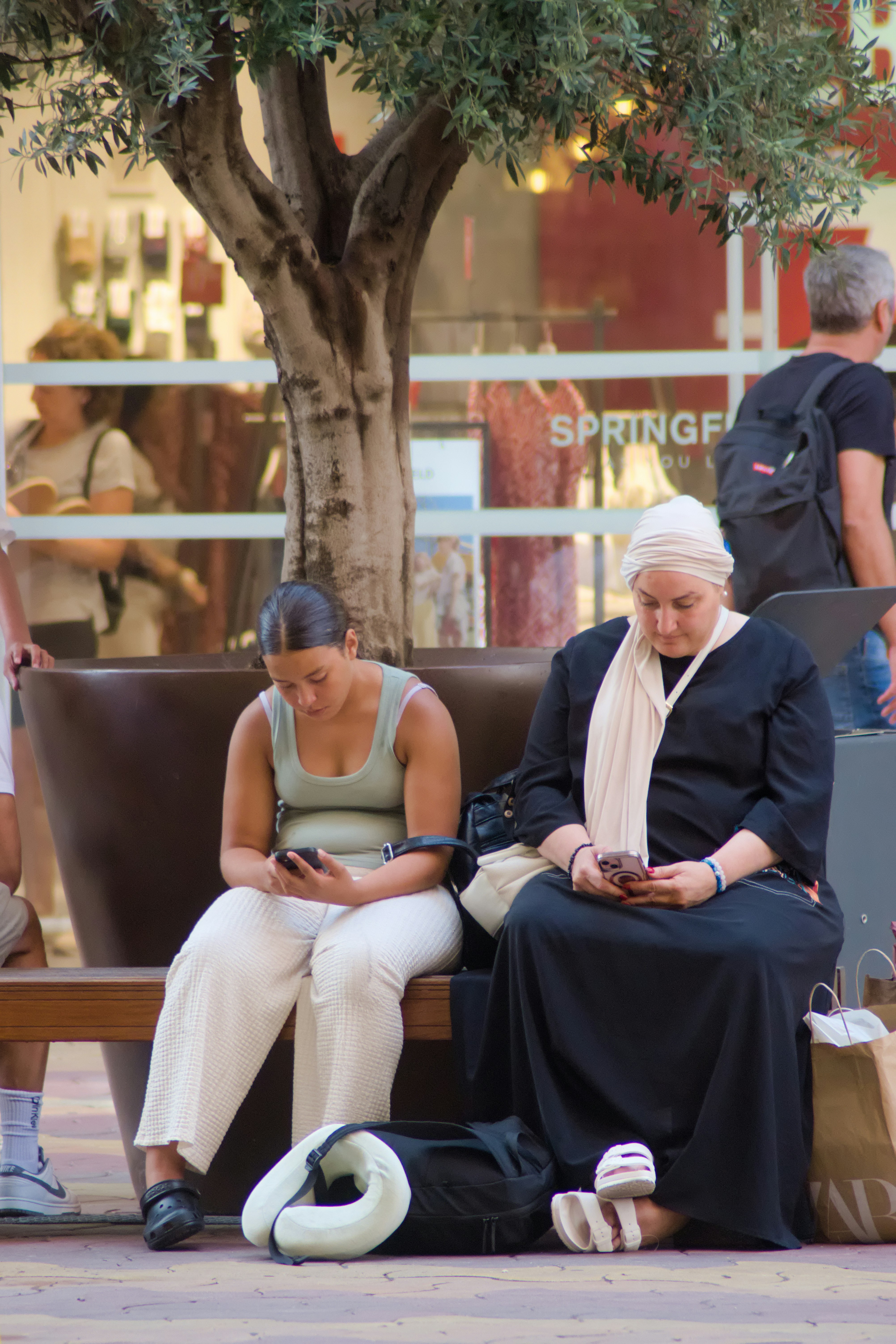 Quiet Moment on the Bench: Two Women Reflecting in the Mall Atrium