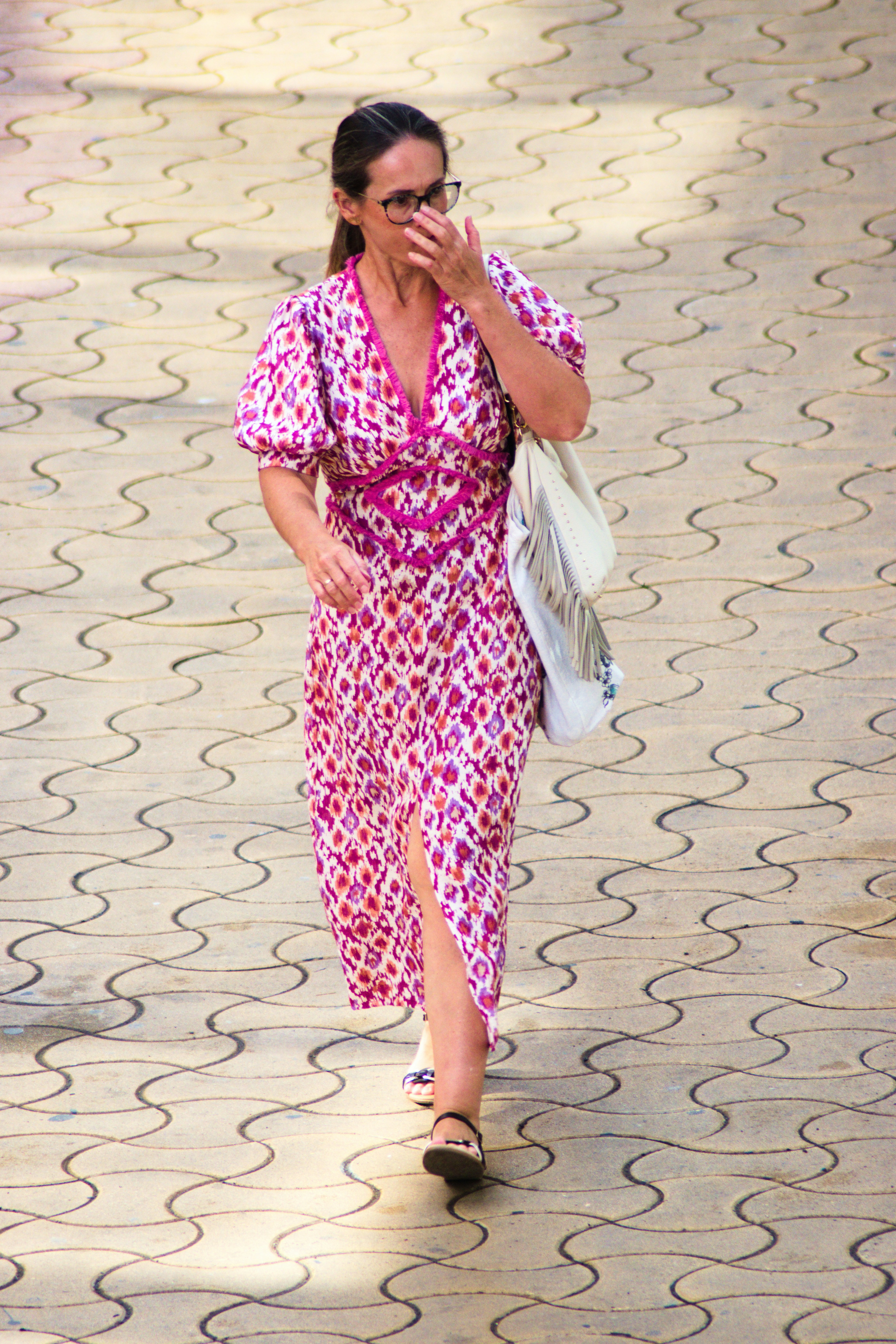 Pink Patterned Dress Walk: A Woman Steps Across a Wavy-Paved Street