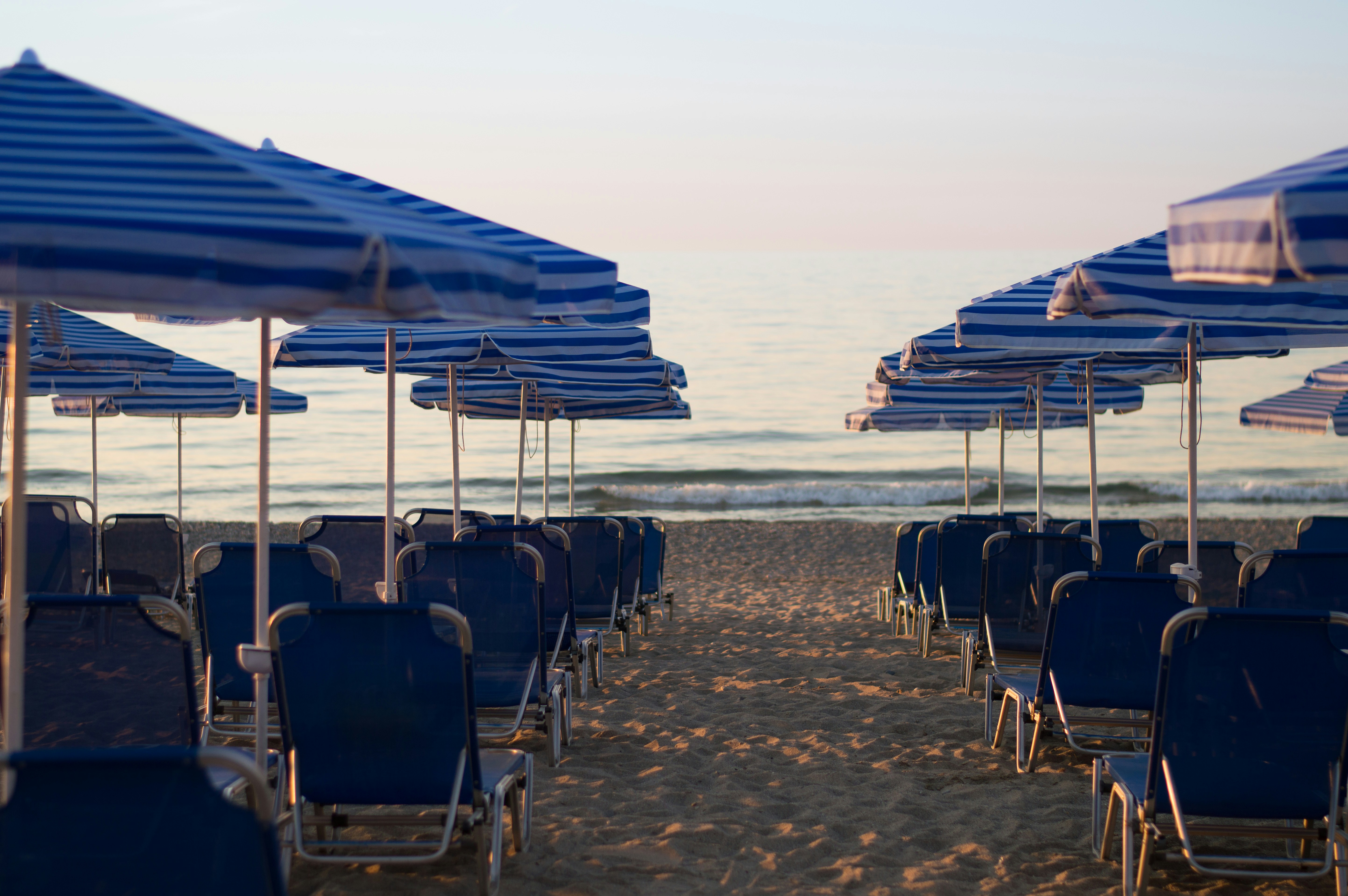 Symmetrical Sea Stillness: Beach Umbrellas Align to the Horizon