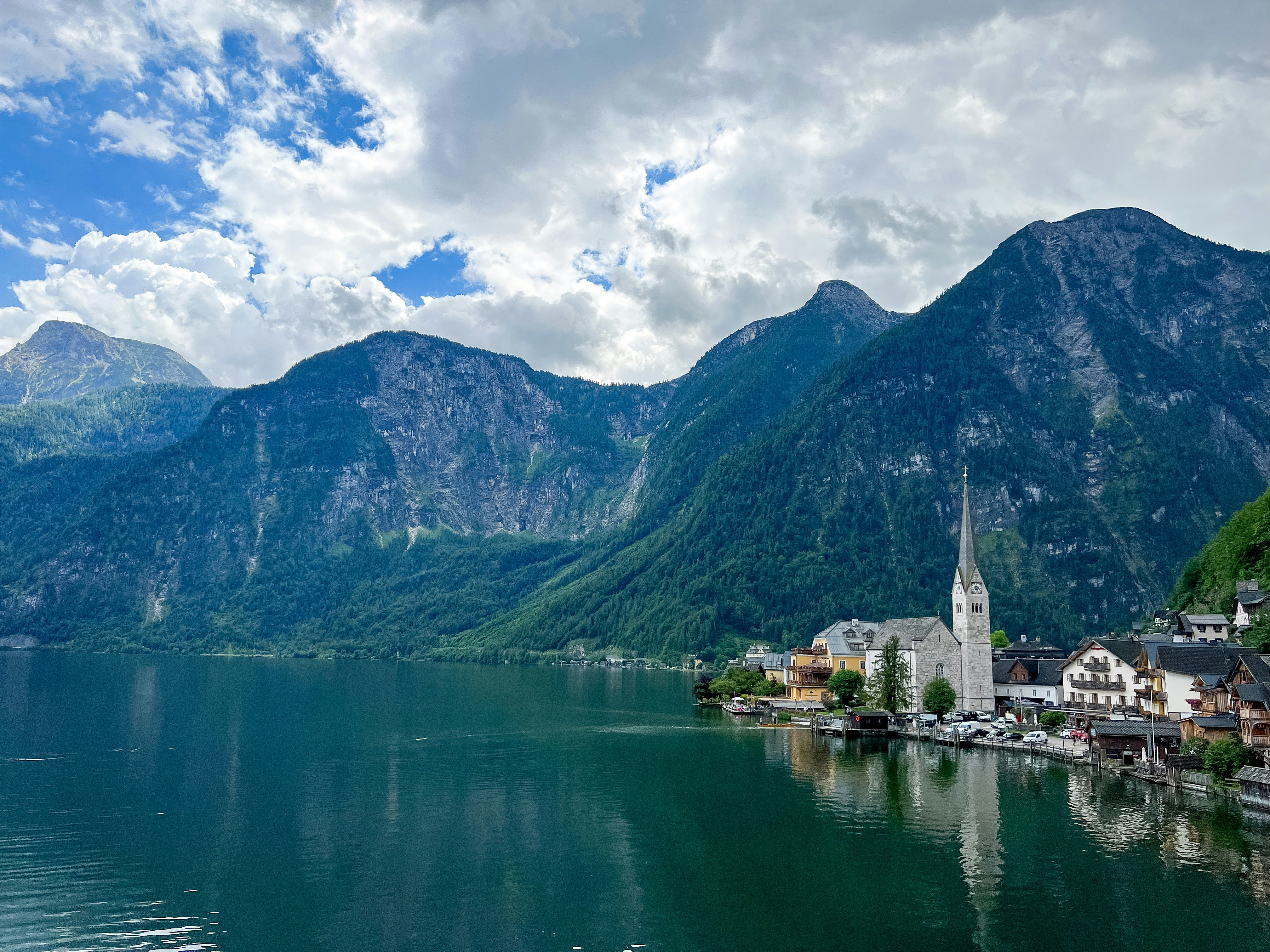 Sunlit Lakeside Village Nestled Between Mountain Peaks