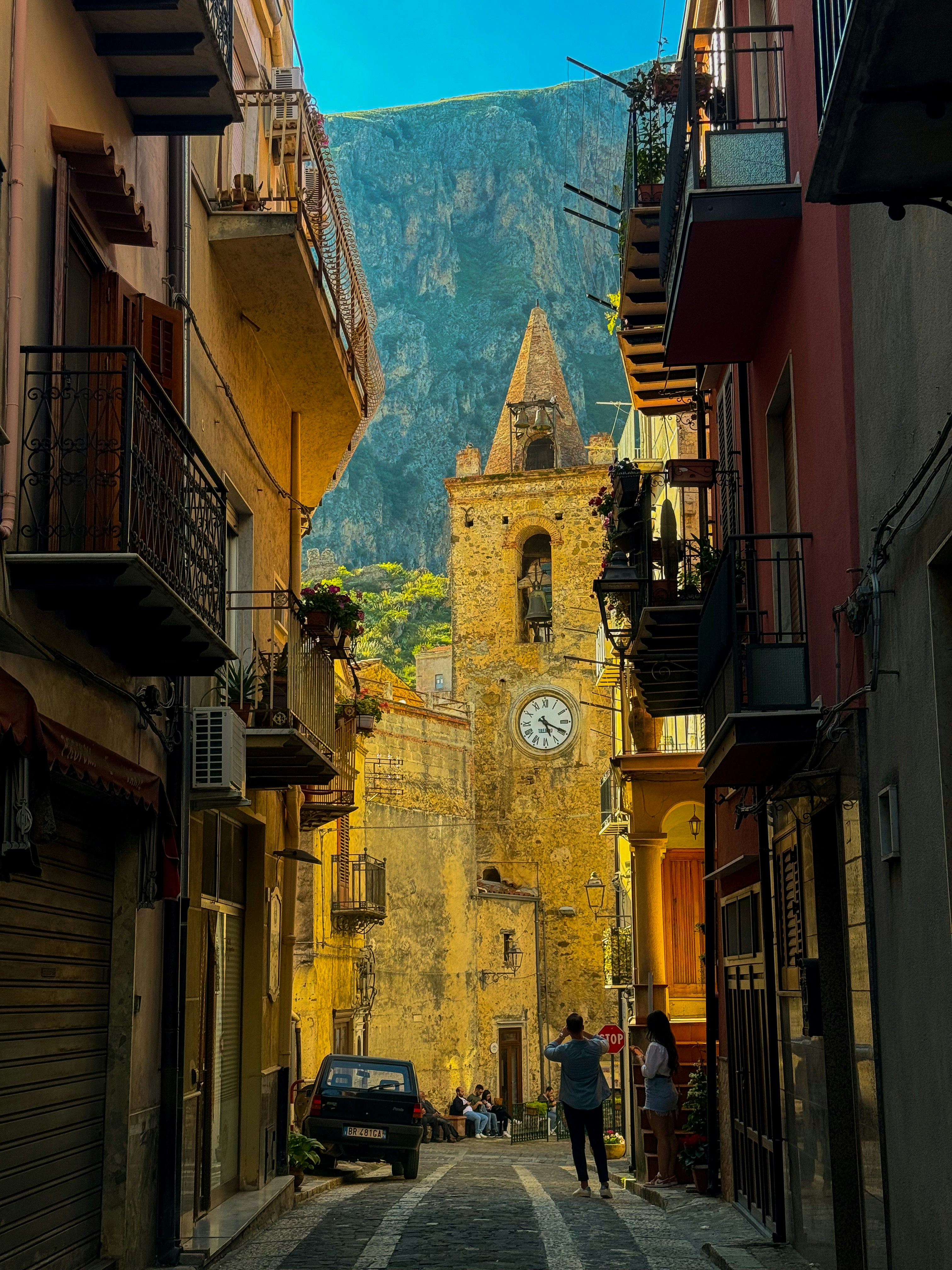 Sunlit Clock Tower Amid a Catalan Street