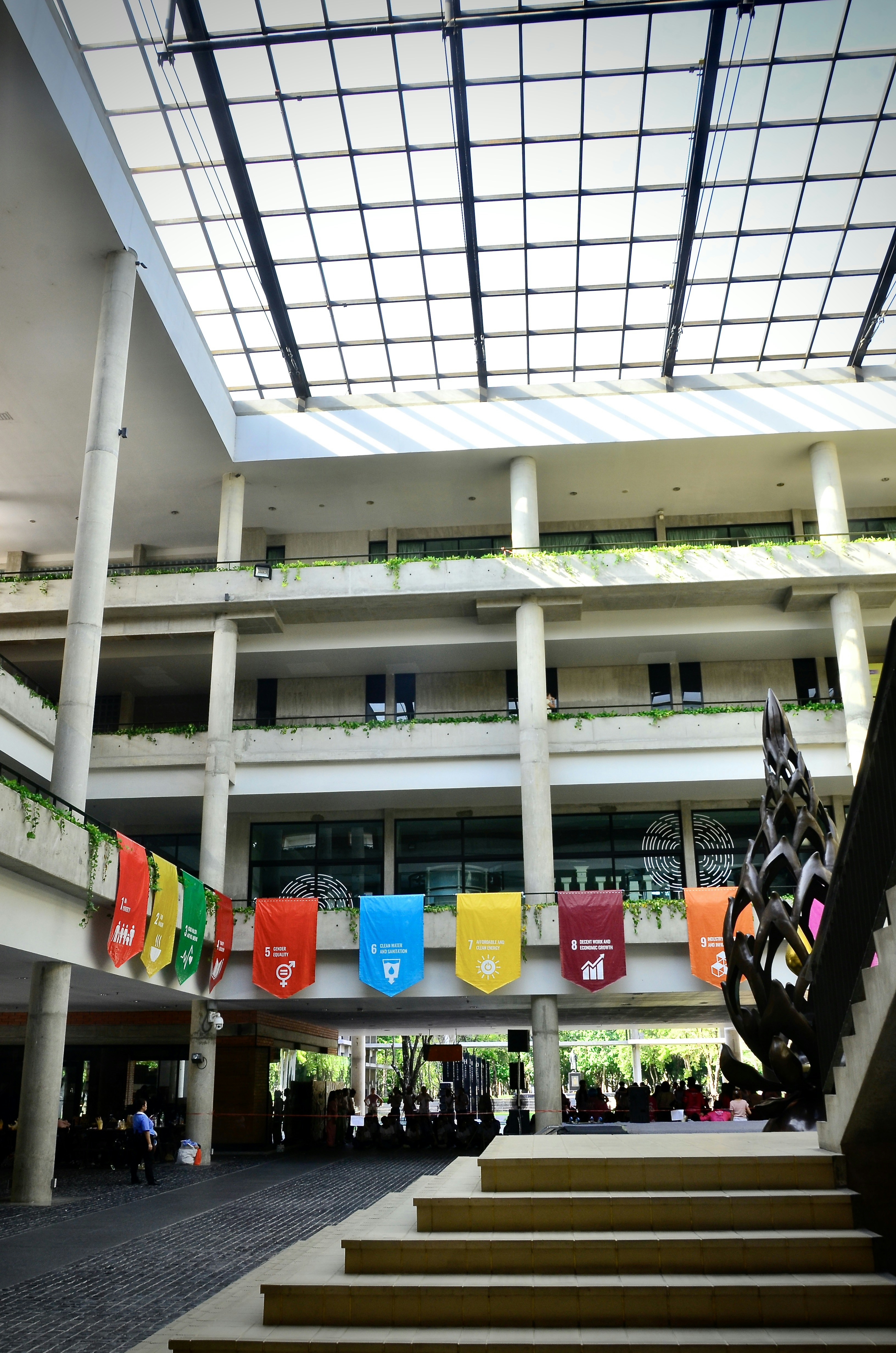 Colorful banners in a sunlit courtyard of a modern atrium