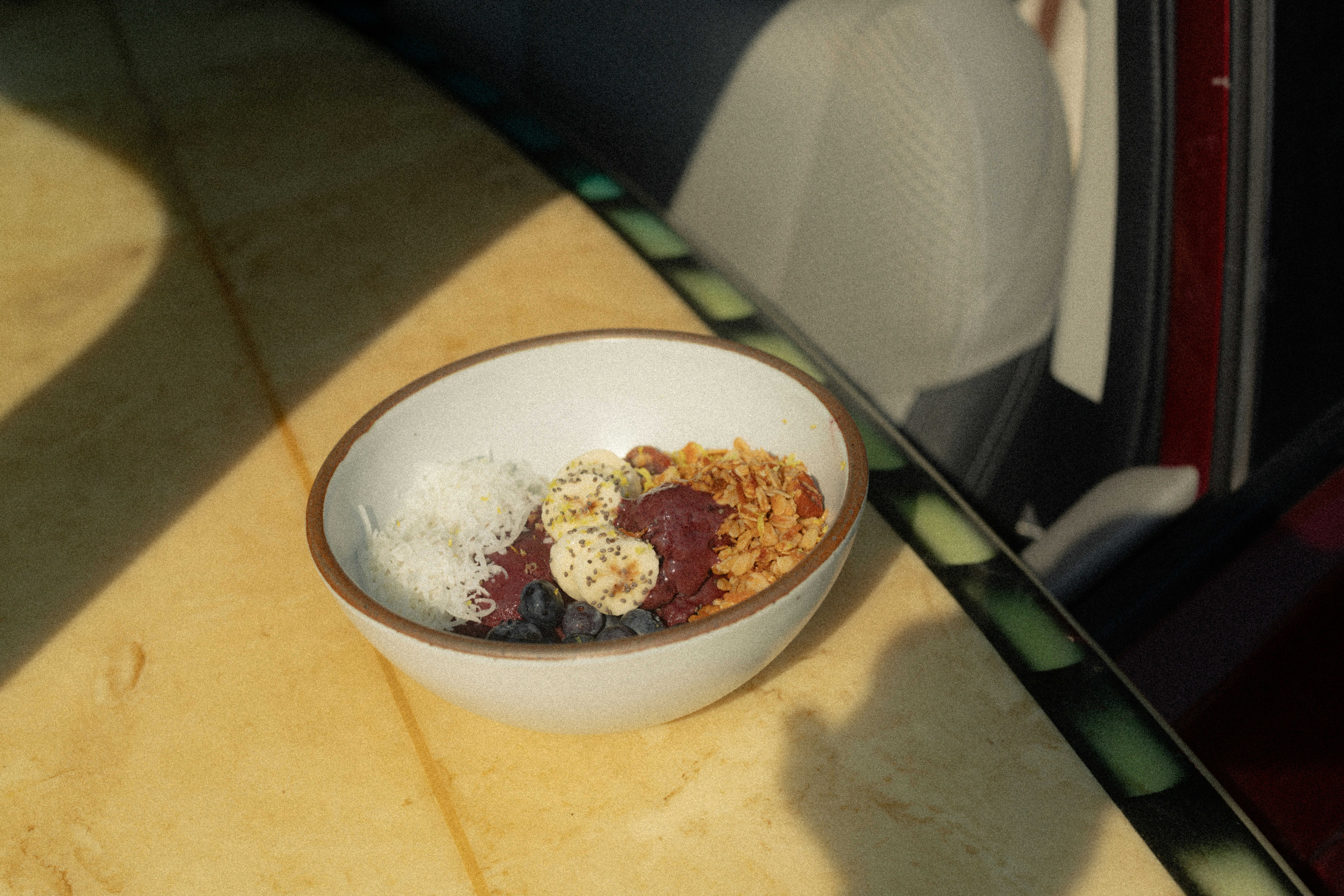 Silky Bowl of Toppings Beside a Car Window